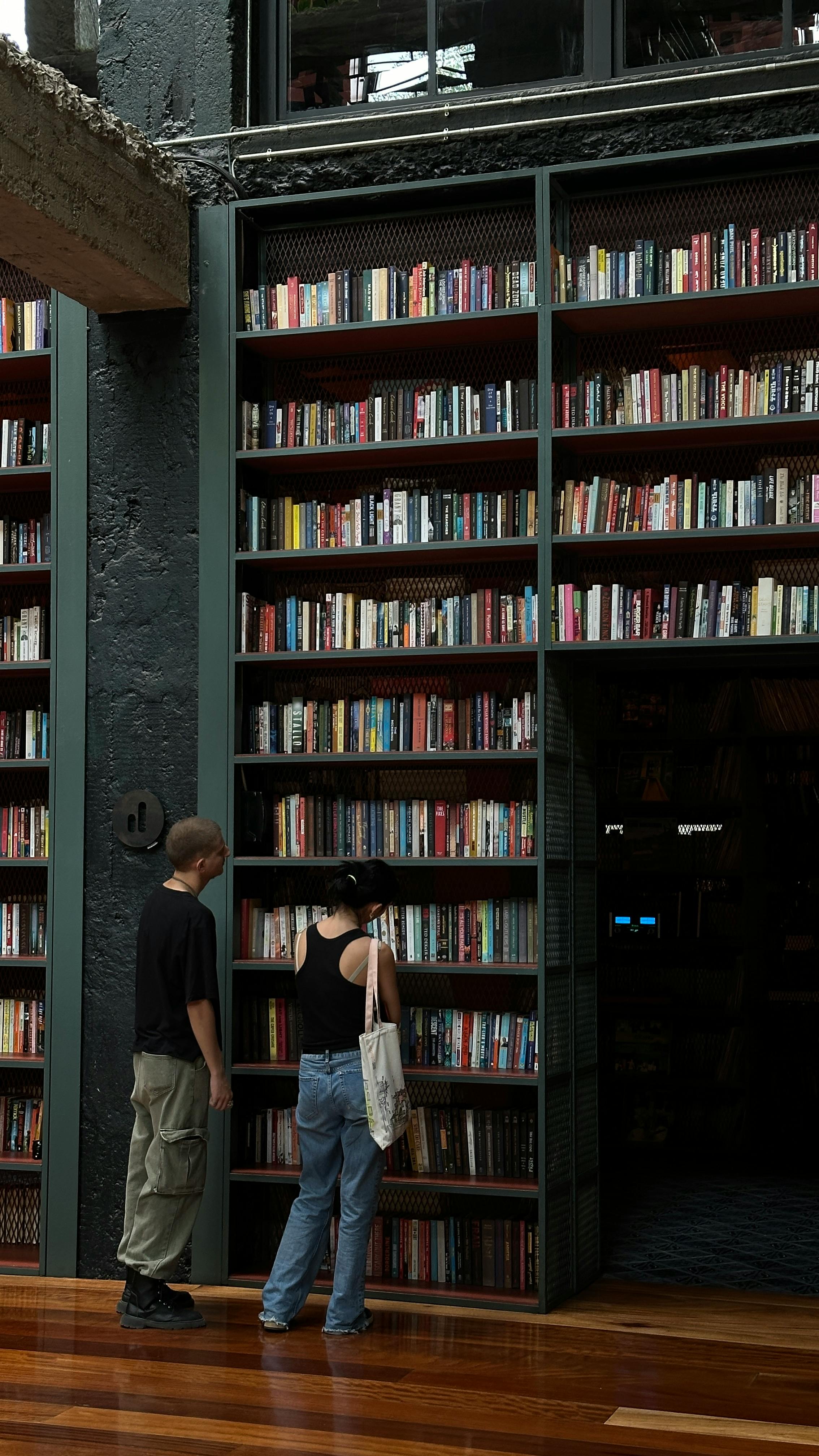 Grayscale Photo of a Woman Holding a Book Inside the Library · Free ...