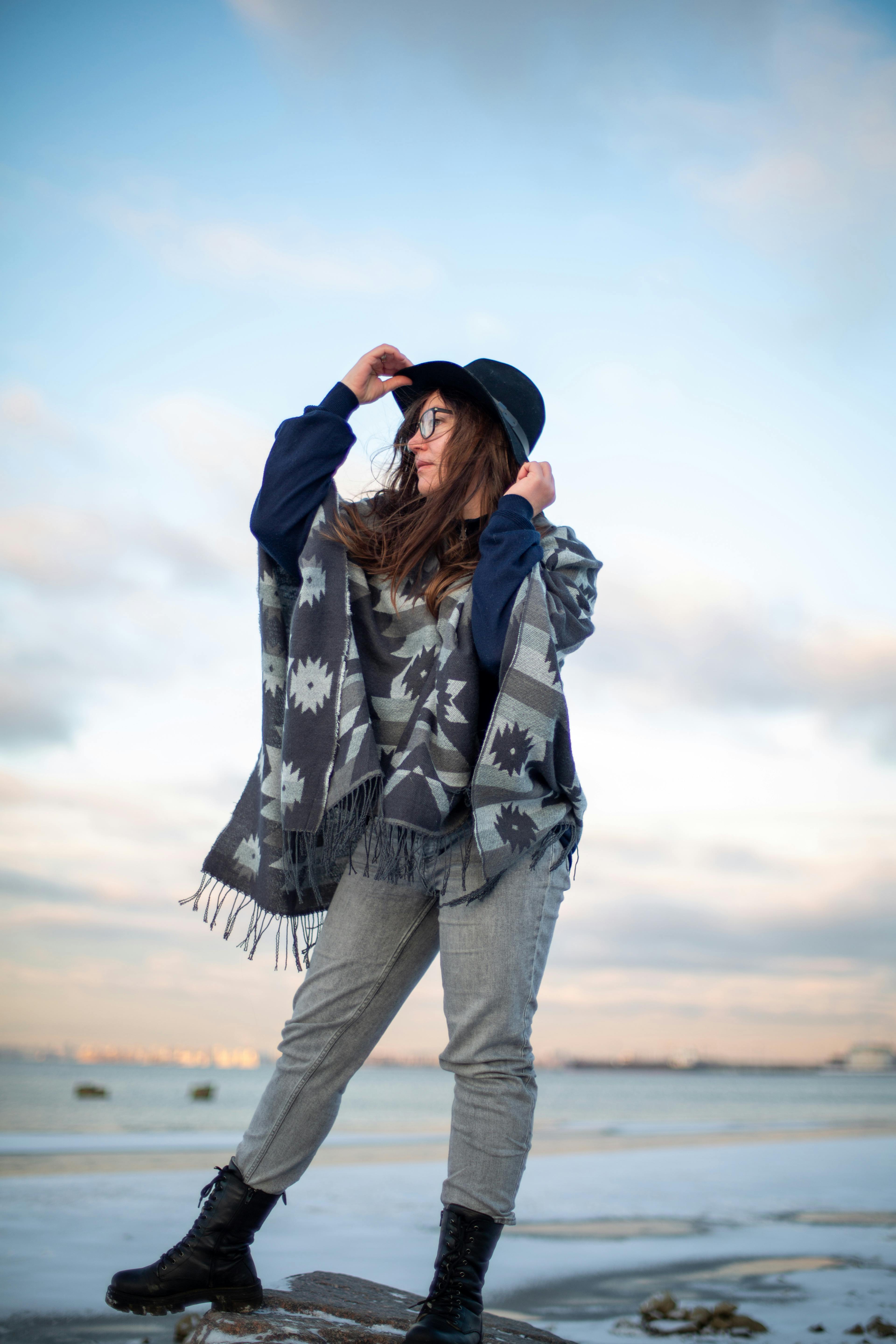 Stylish Woman in Poncho by the Sea · Free Stock Photo