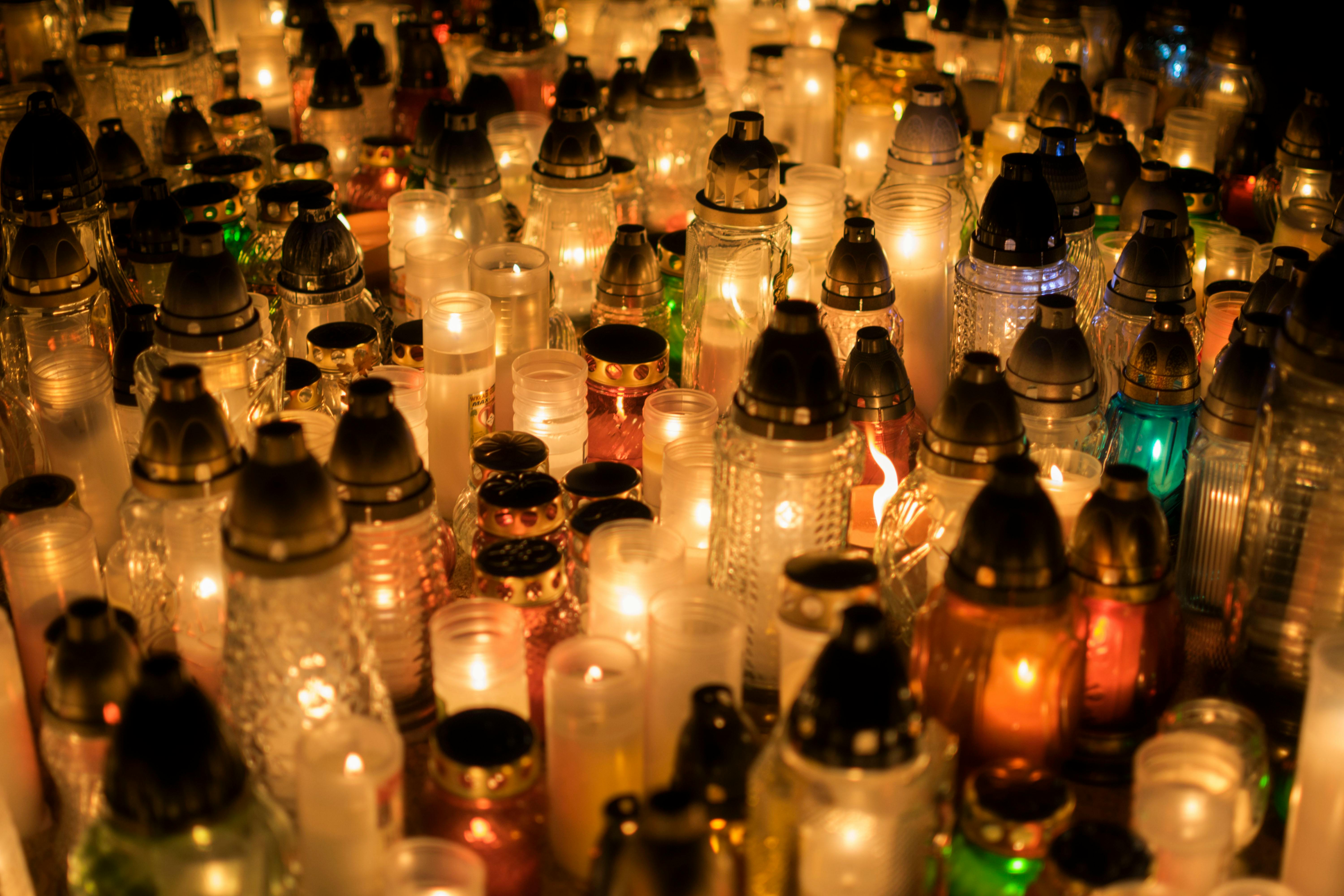 Illuminated Cemetery Grave Candles at Night · Free Stock Photo