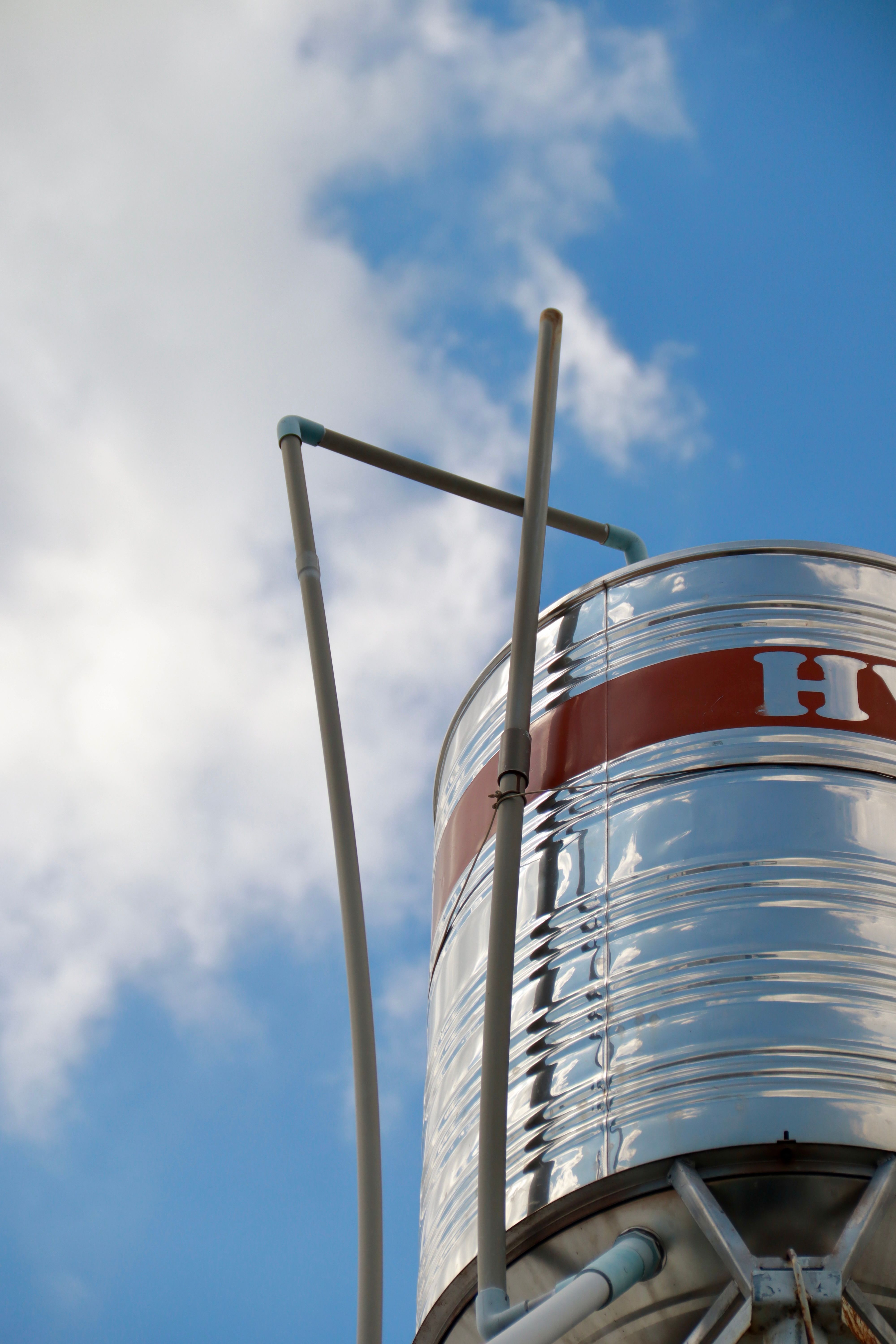 Silver Water Tank Against a Blue Sky · Free Stock Photo