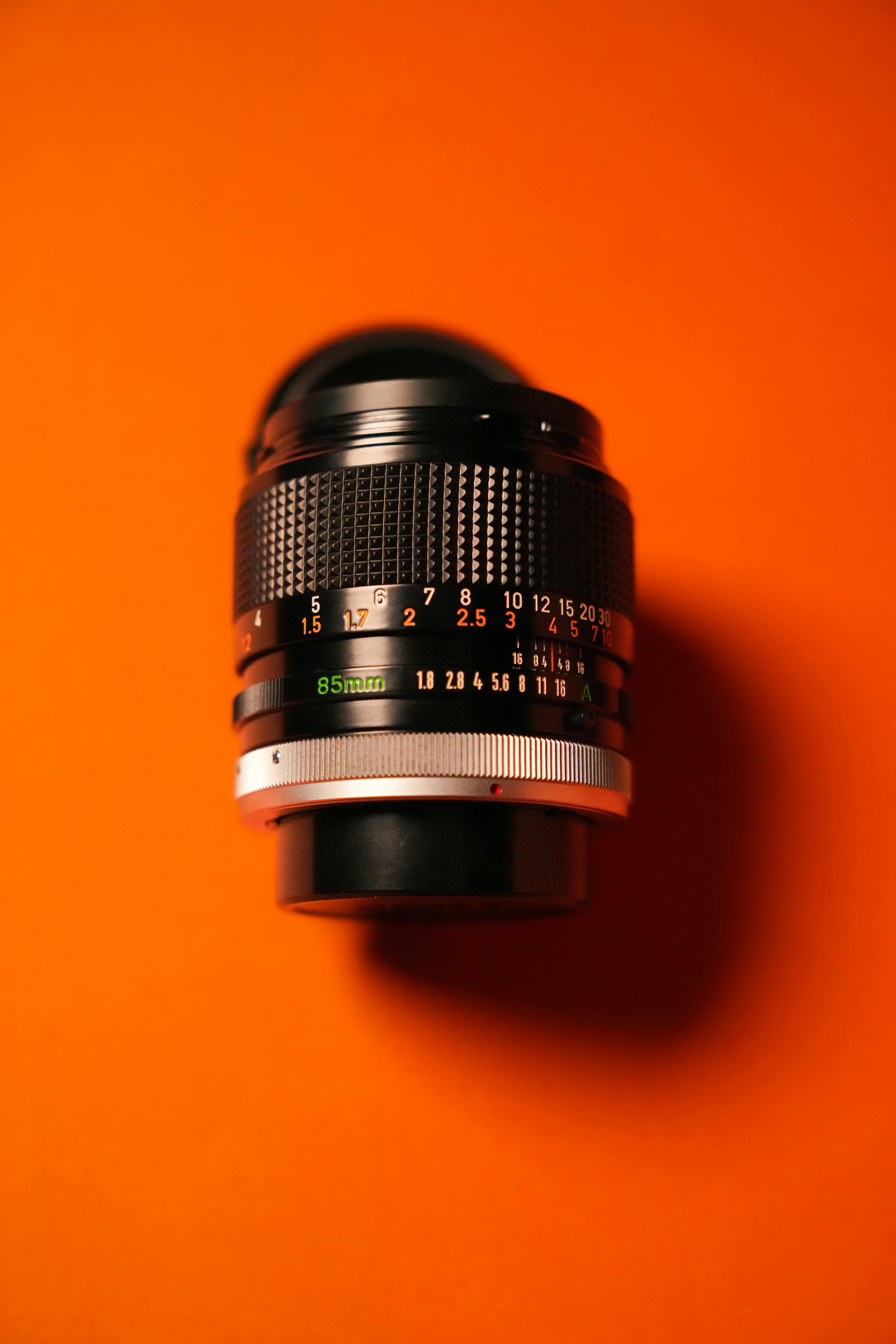 Close-up of Camera Lens on Vibrant Orange Background · Free Stock Photo