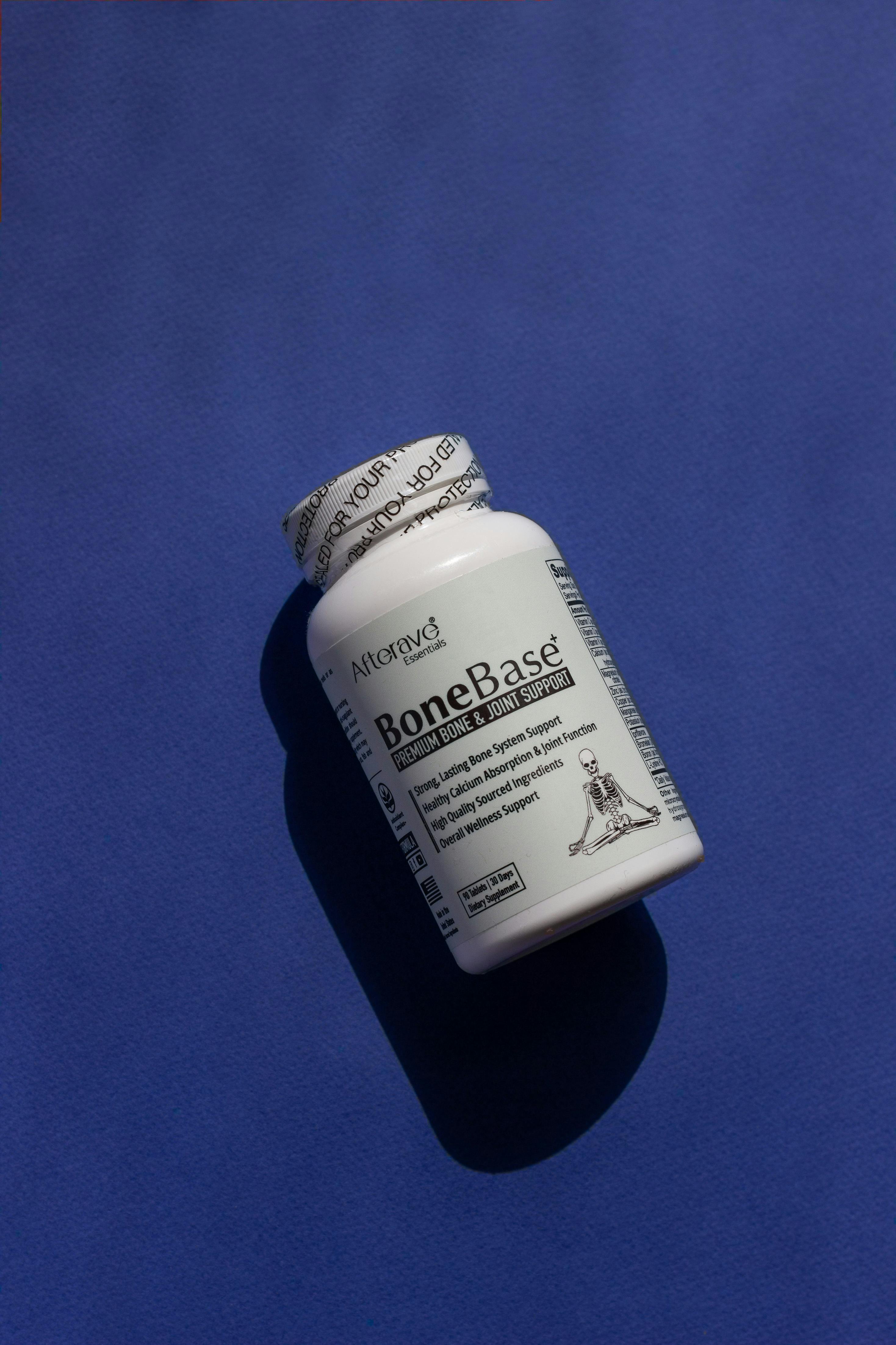 Bone Supplement Bottle on a Blue Background · Free Stock Photo