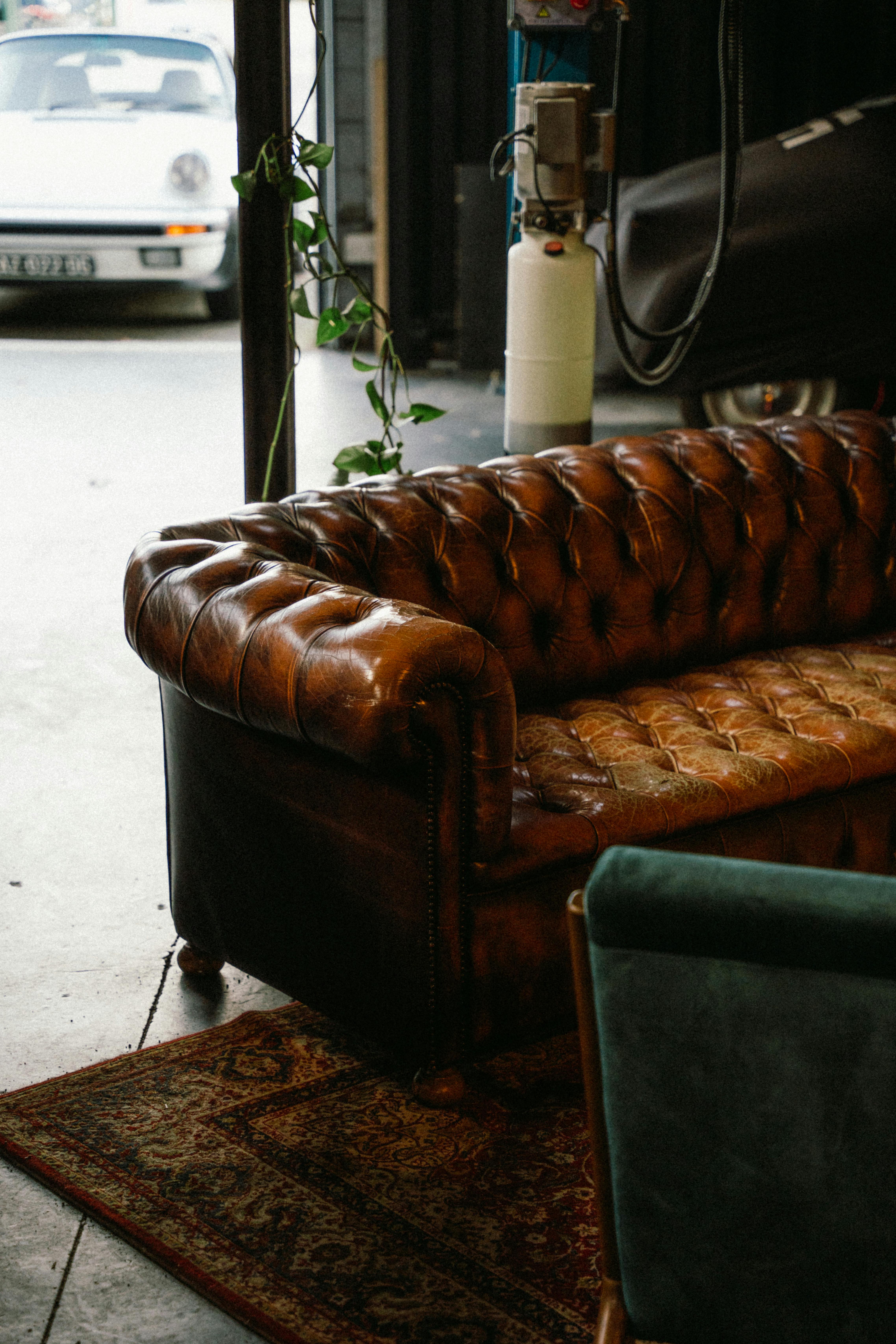 Vintage Leather Sofa in Stylish Garage Setting · Free Stock Photo