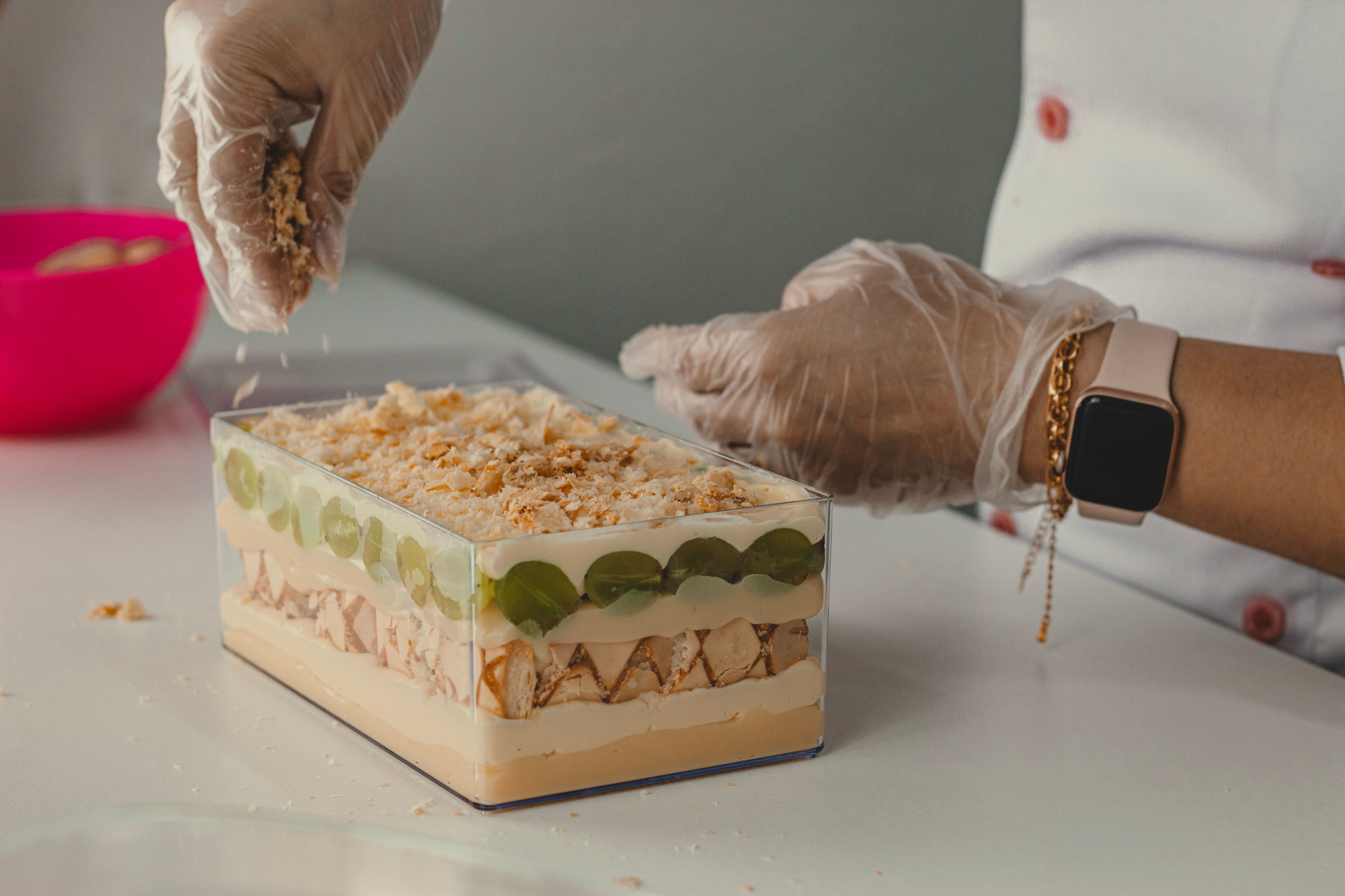 Person Preparing a Layered Dessert in Kitchen · Free Stock Photo