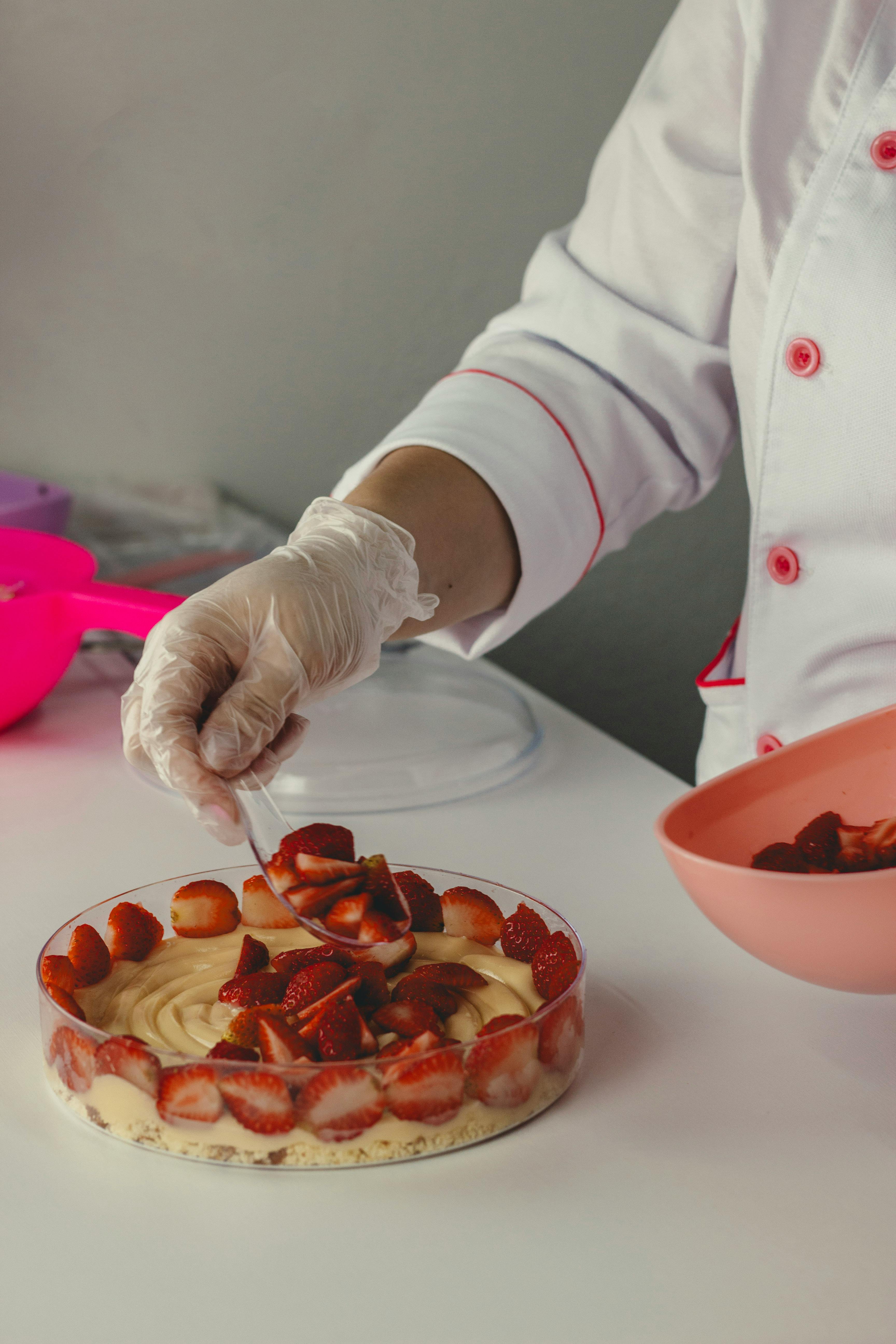 Chef Decorando Un Pastel De Fresas En La Cocina · Foto de stock gratuita
