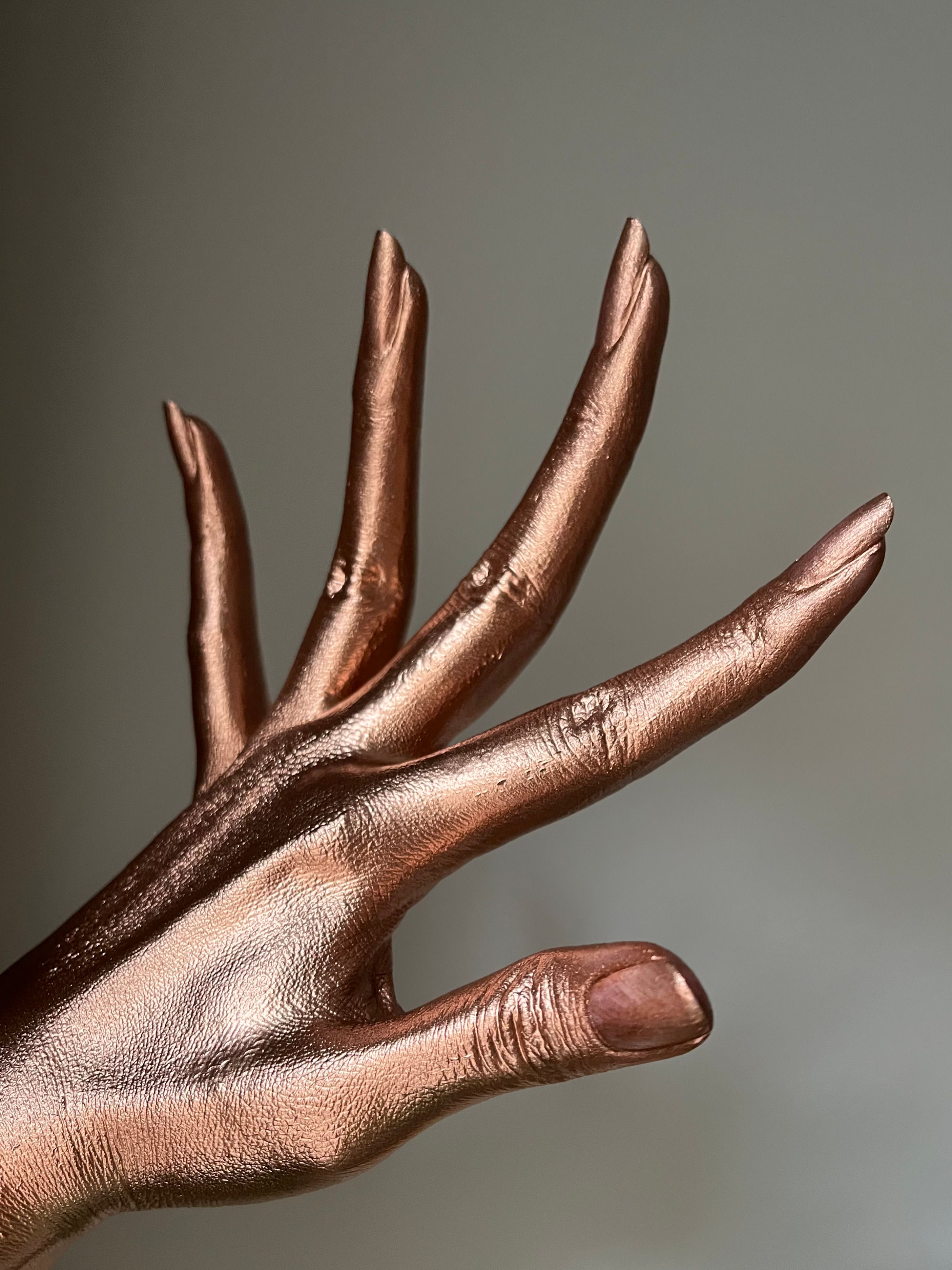 Artistic Bronze Painted Hand Close-Up · Free Stock Photo