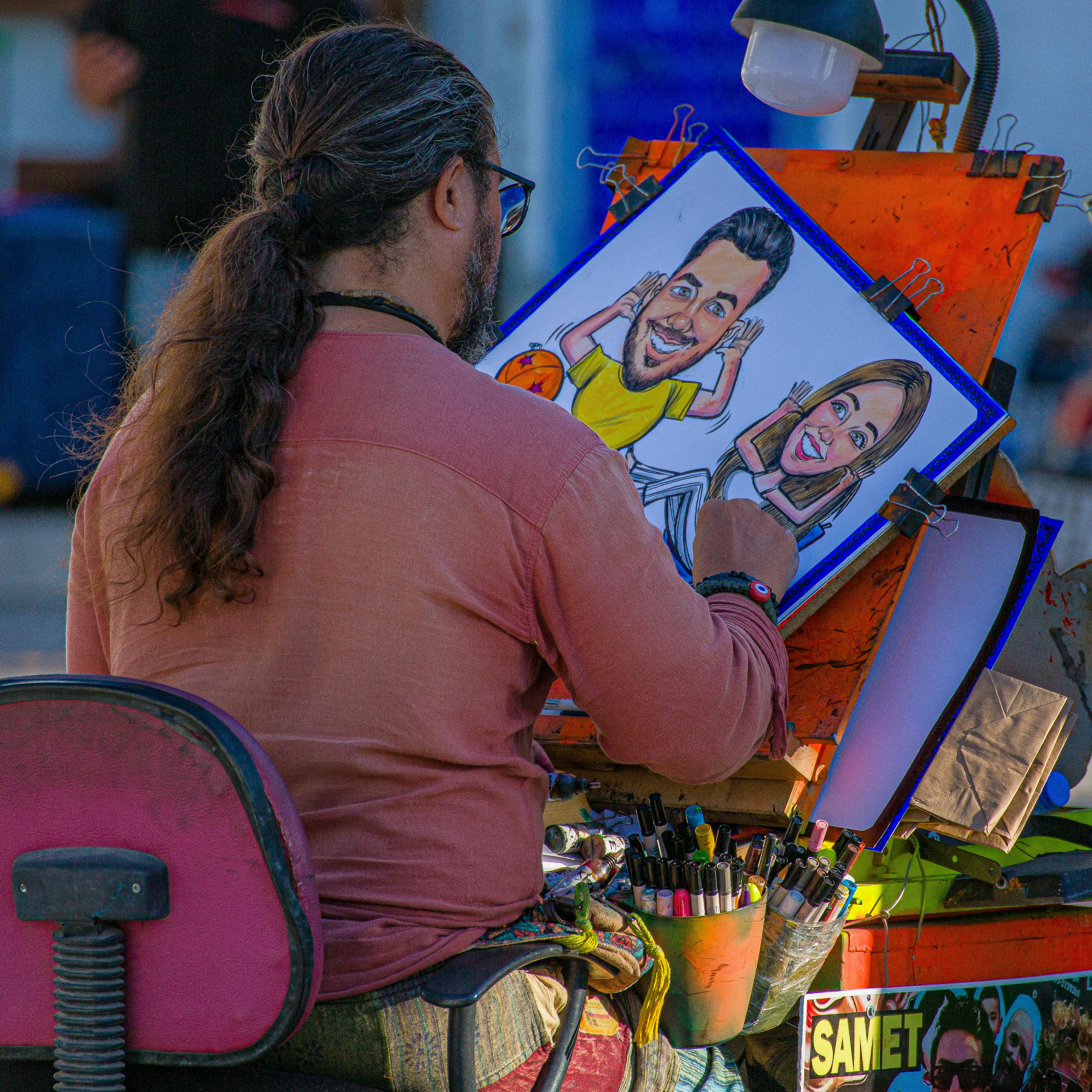 Street Artist Creating Lively Caricature Portraits · Free Stock Photo