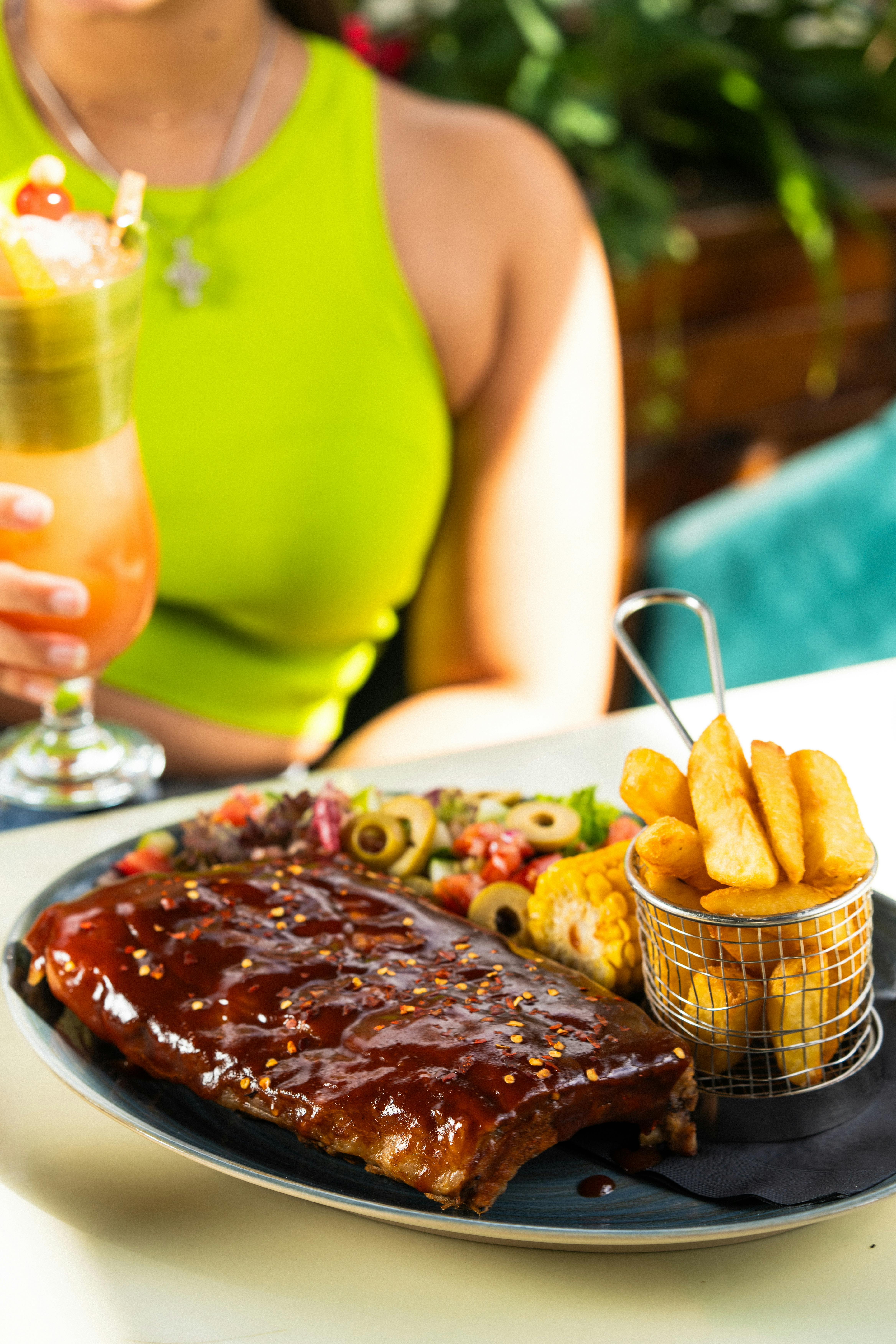 Delicious Barbecue Ribs with Tropical Cocktail · Free Stock Photo