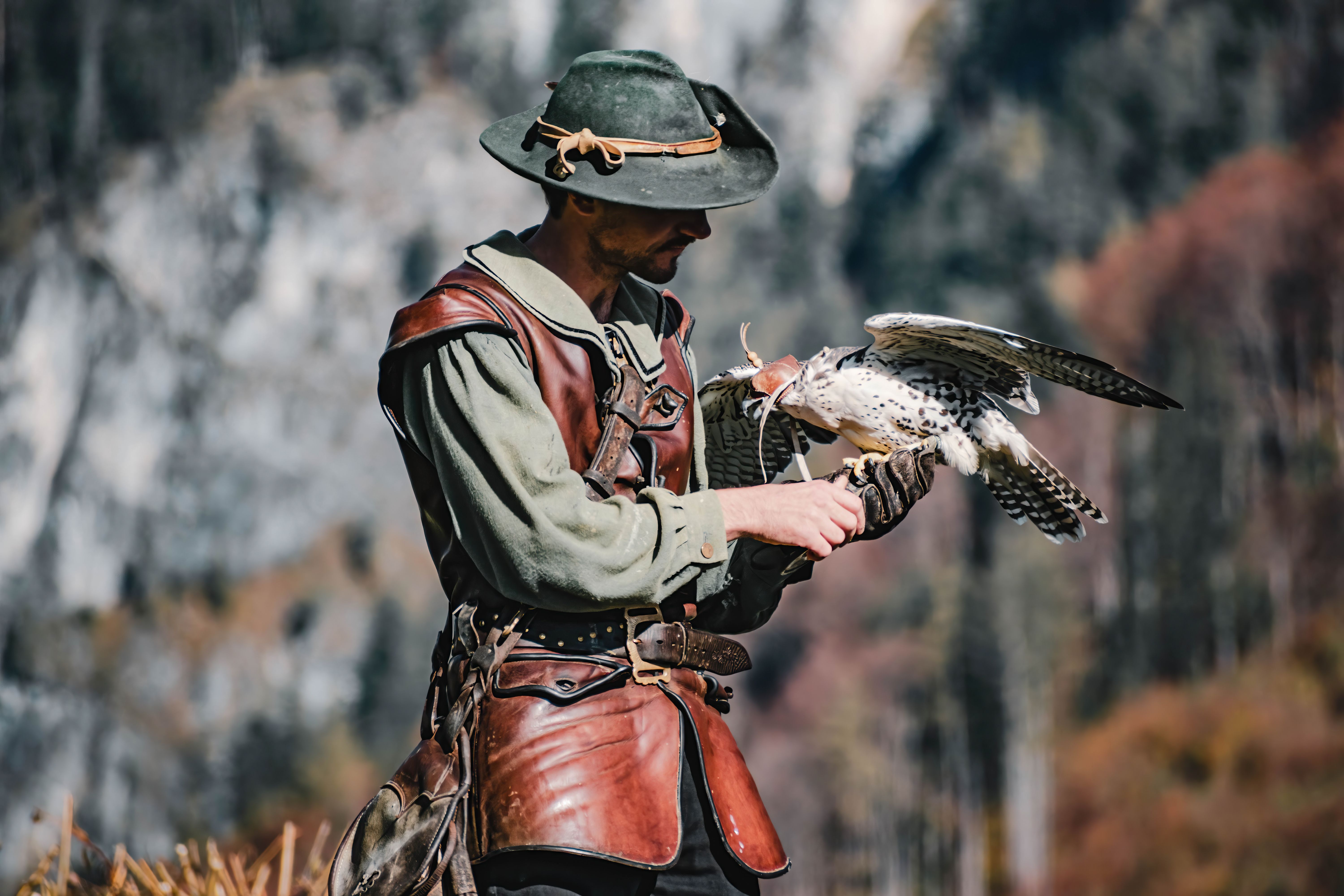 Falconer with Bird in Traditional Attire Outdoors · Free Stock Photo