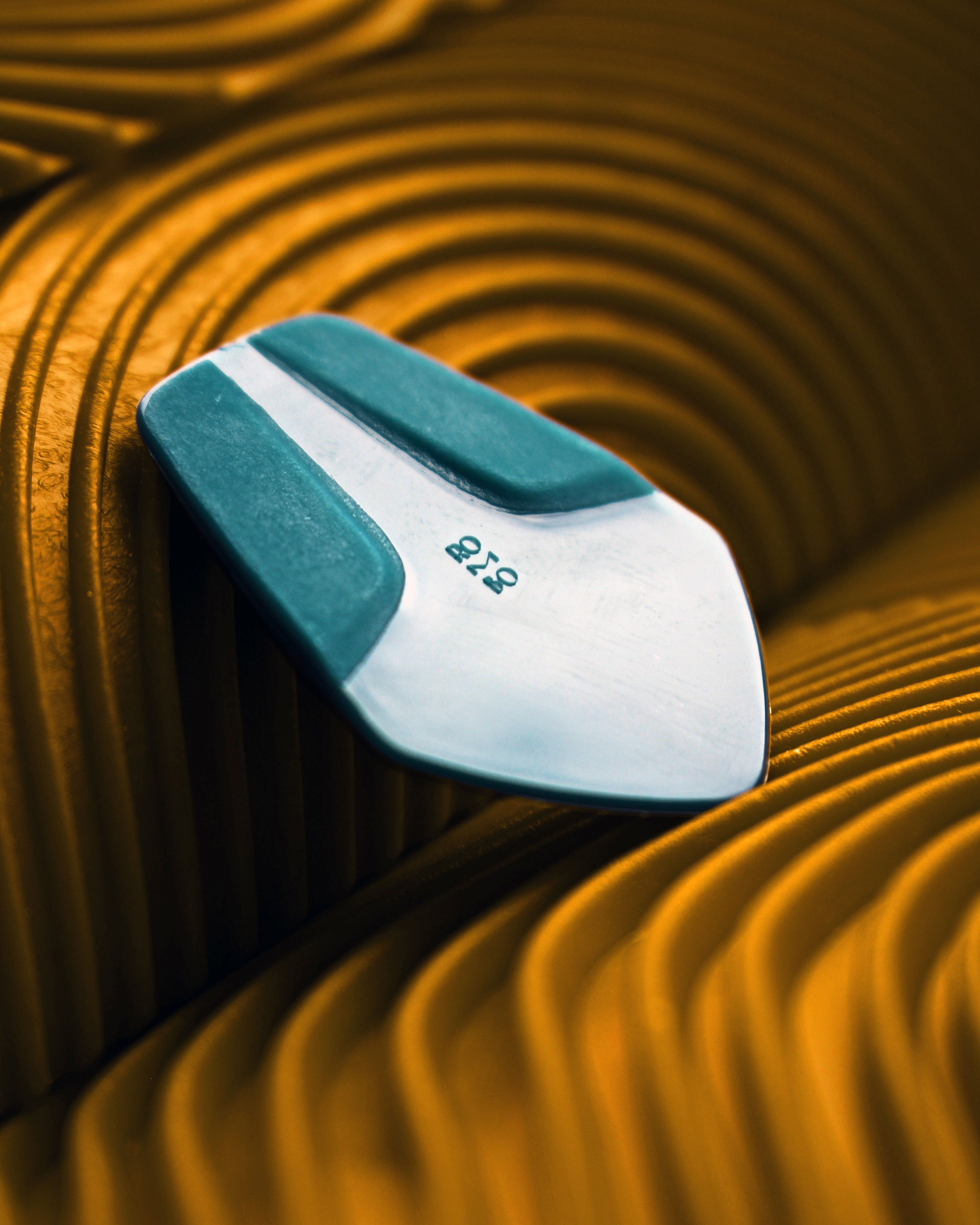 Abstract Close-Up of Guitar Pick on Textured Surface · Free Stock Photo