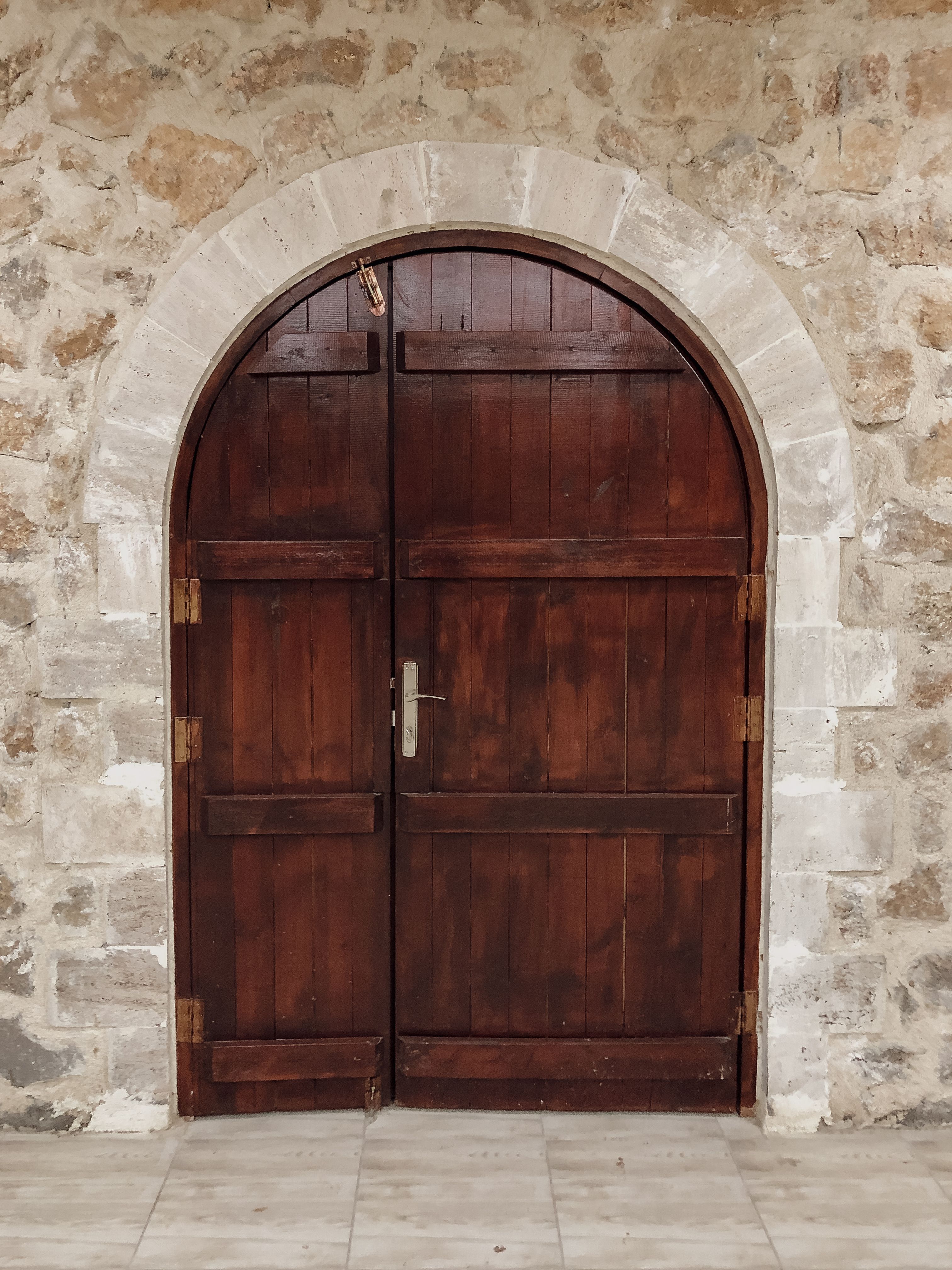 Rustic Wooden Door in Stone Wall Archway · Free Stock Photo