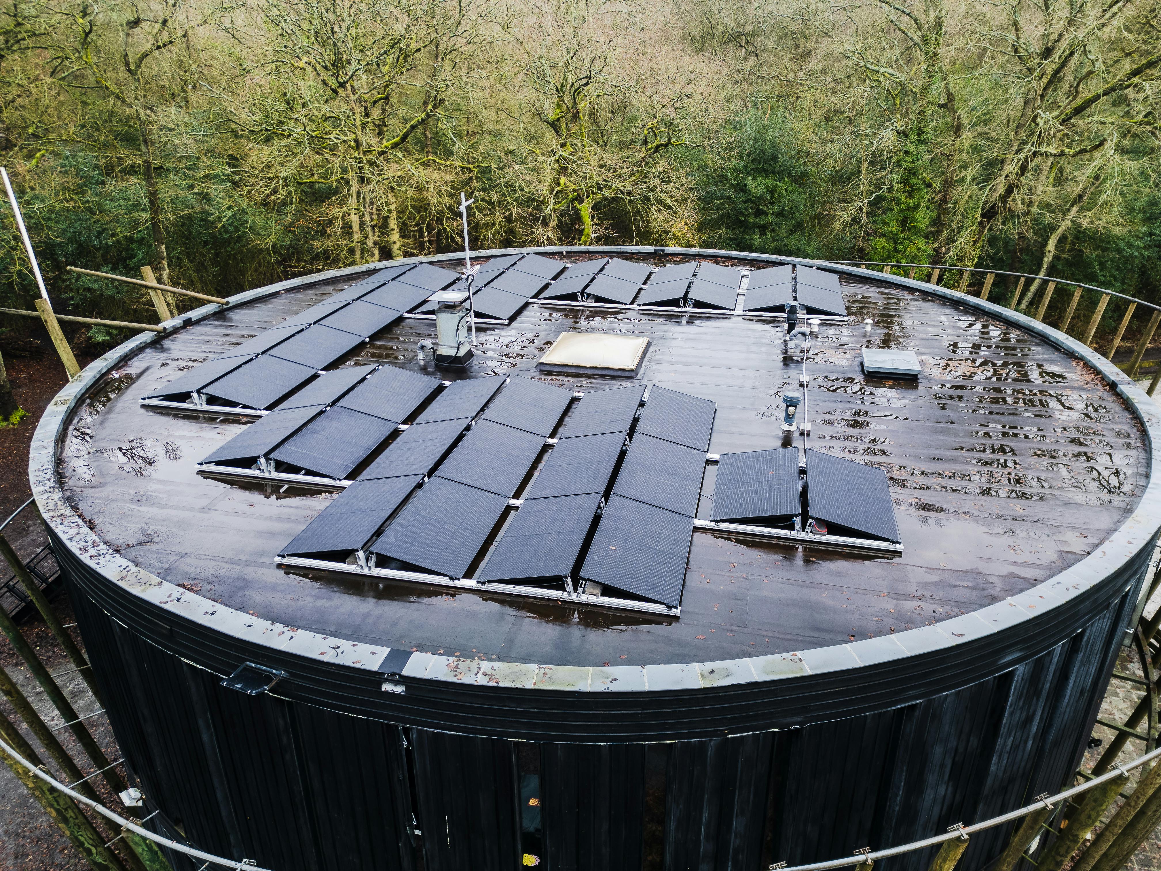 Circular Rooftop with Solar Panels in Forested Area · Free Stock Photo