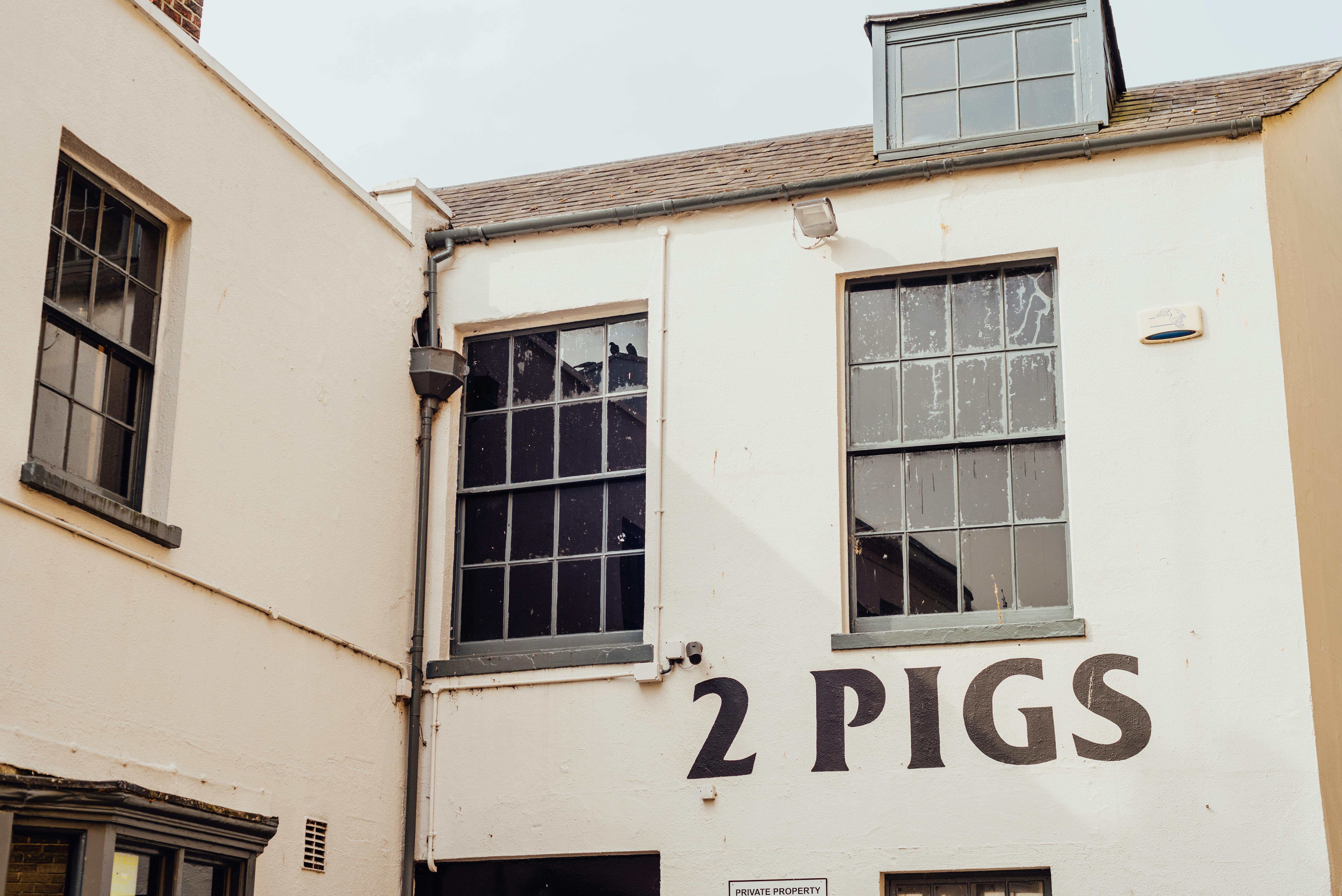 Urban Architecture Featuring '2 Pigs' Sign · Free Stock Photo