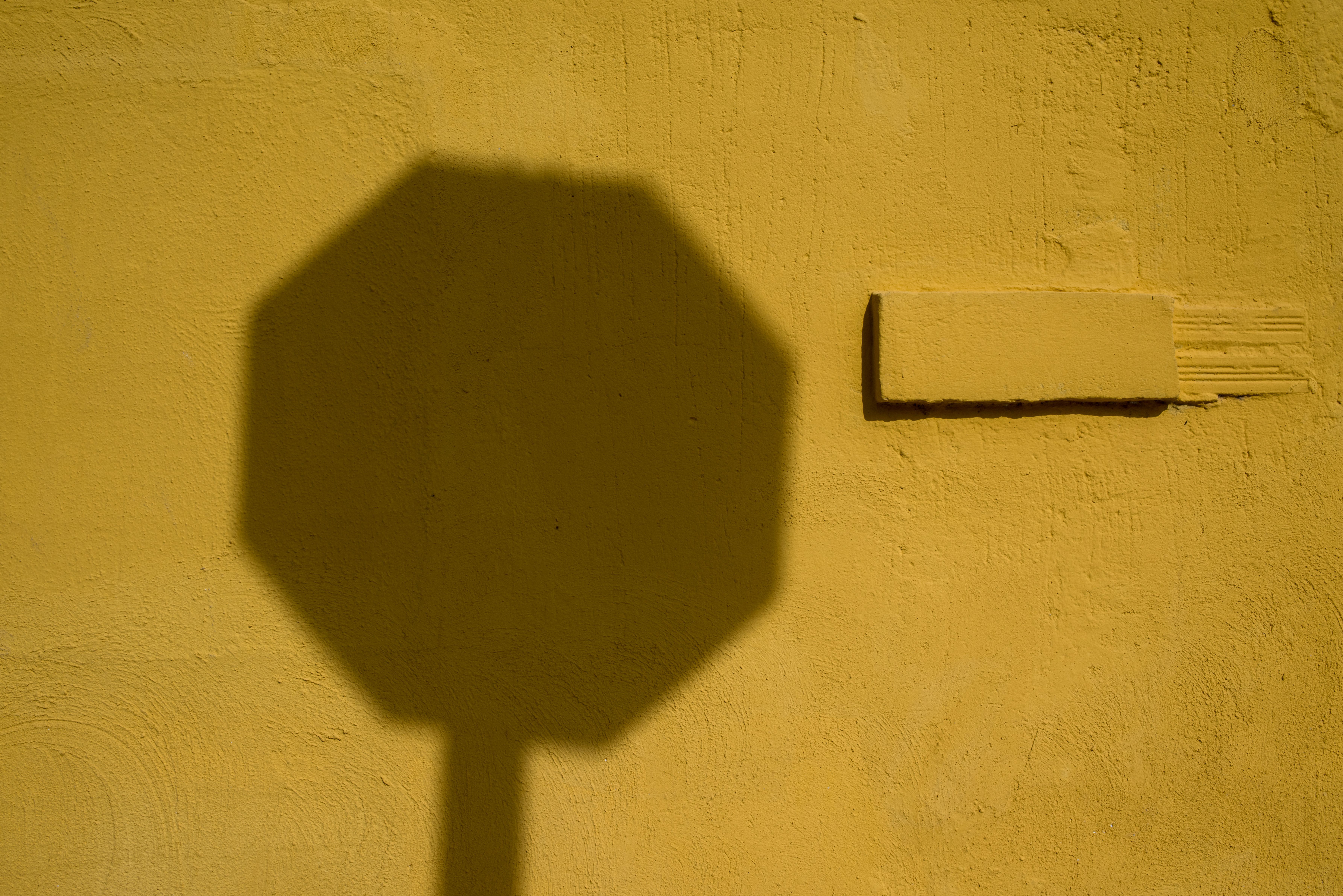 Shadow of Stop Sign on Yellow Wall · Free Stock Photo