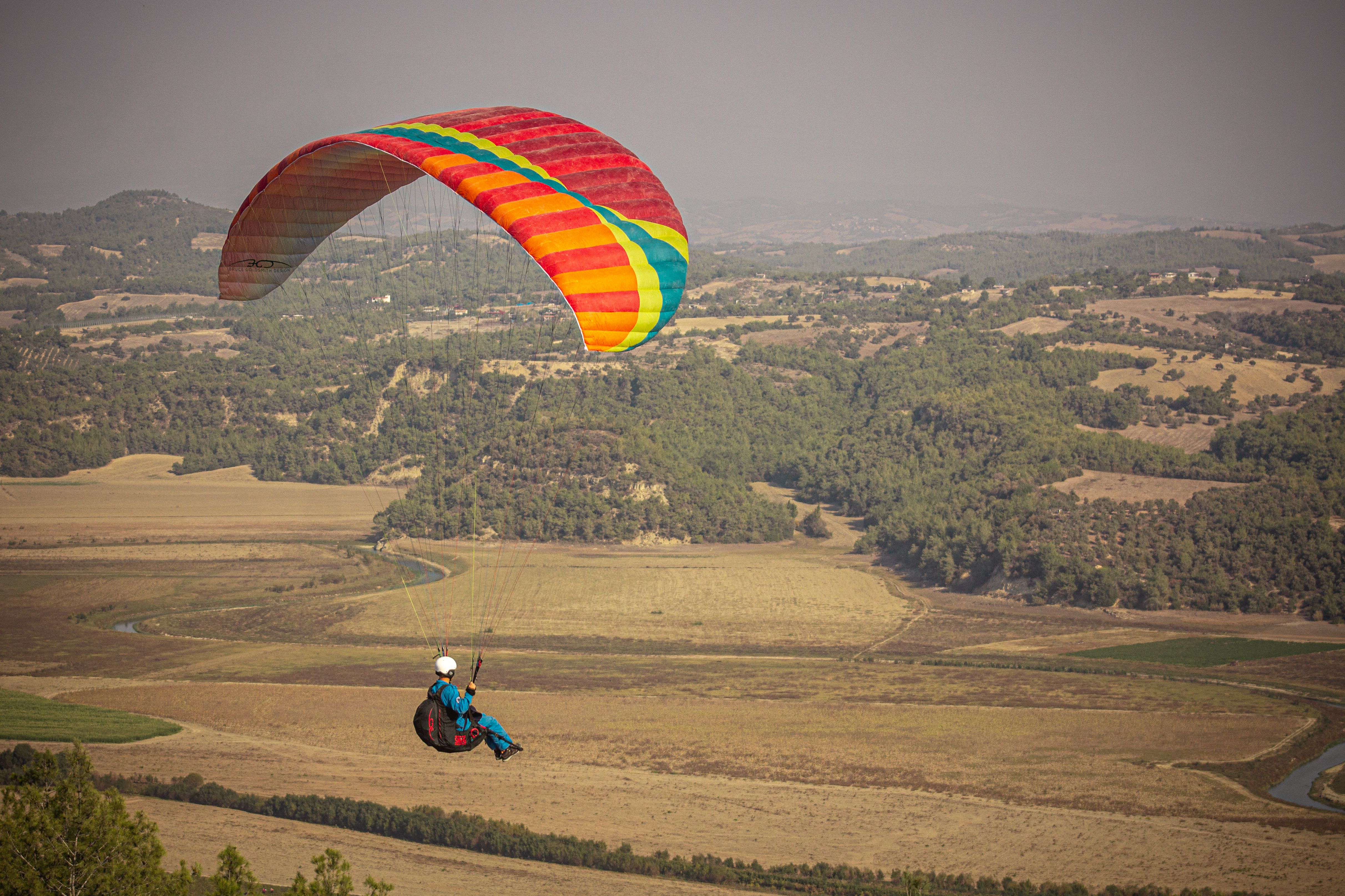 Colorful Paraglider Over Scenic Landscape · Free Stock Photo
