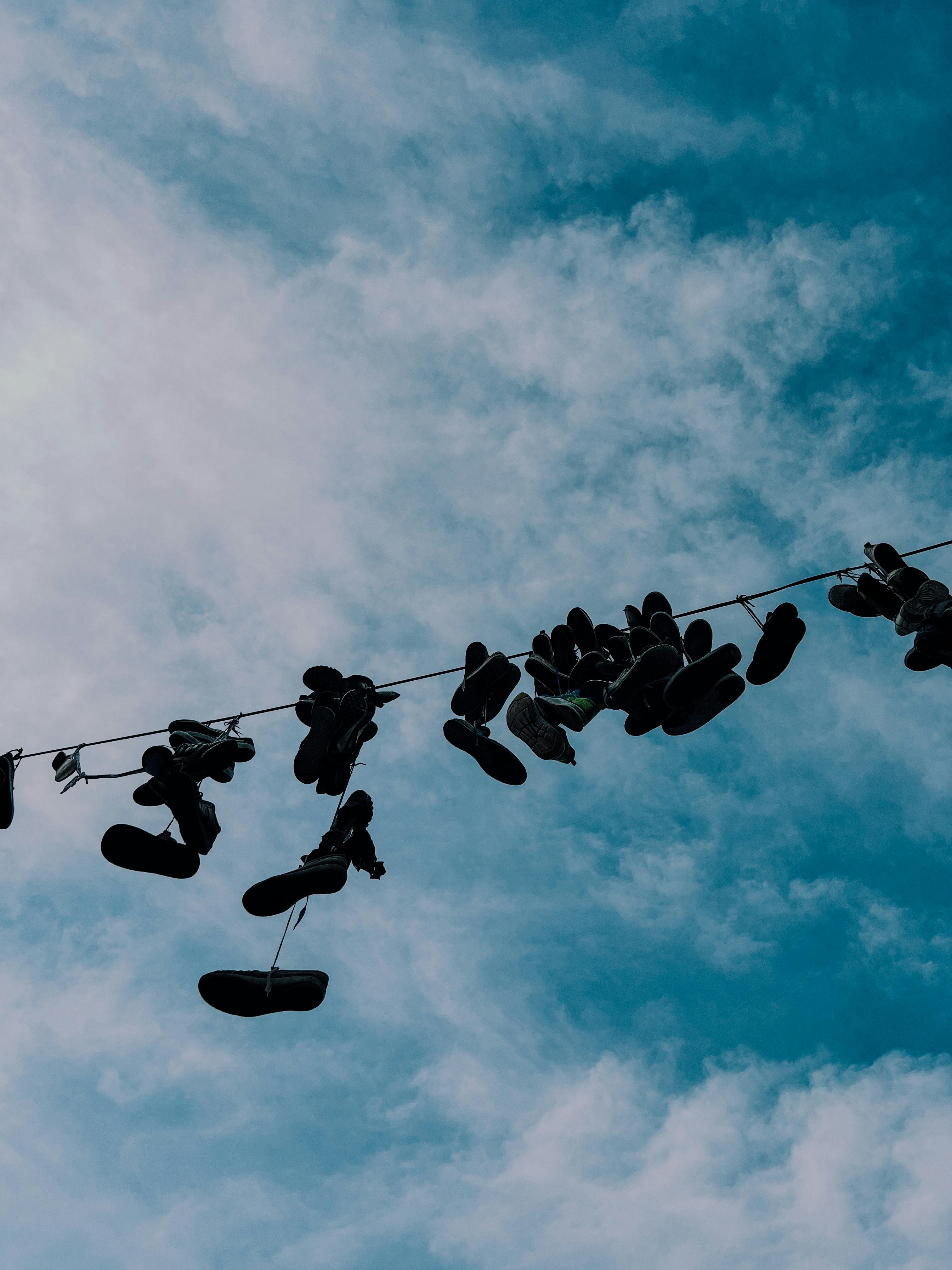 Hanging Shoes on a Wire Against Blue Sky · Free Stock Photo