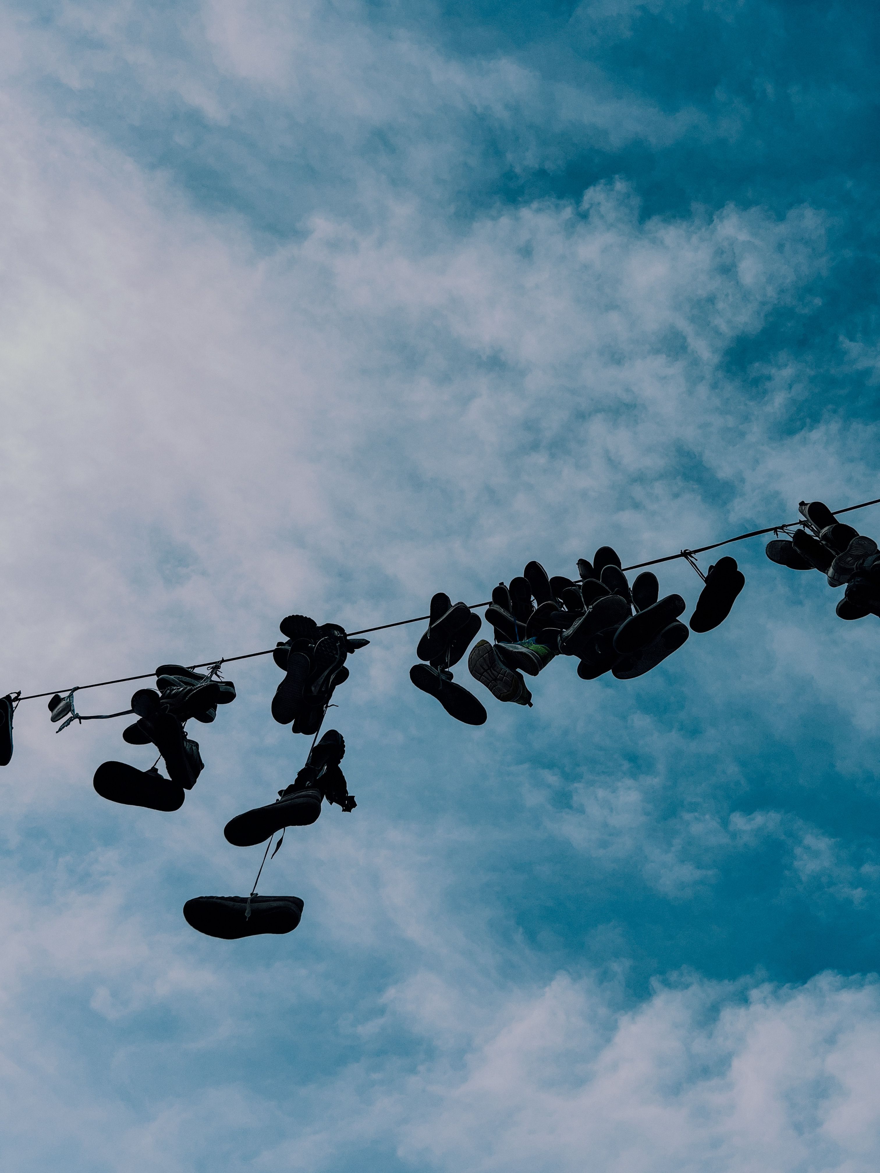 Hanging Shoes on a Wire Against Blue Sky · Free Stock Photo