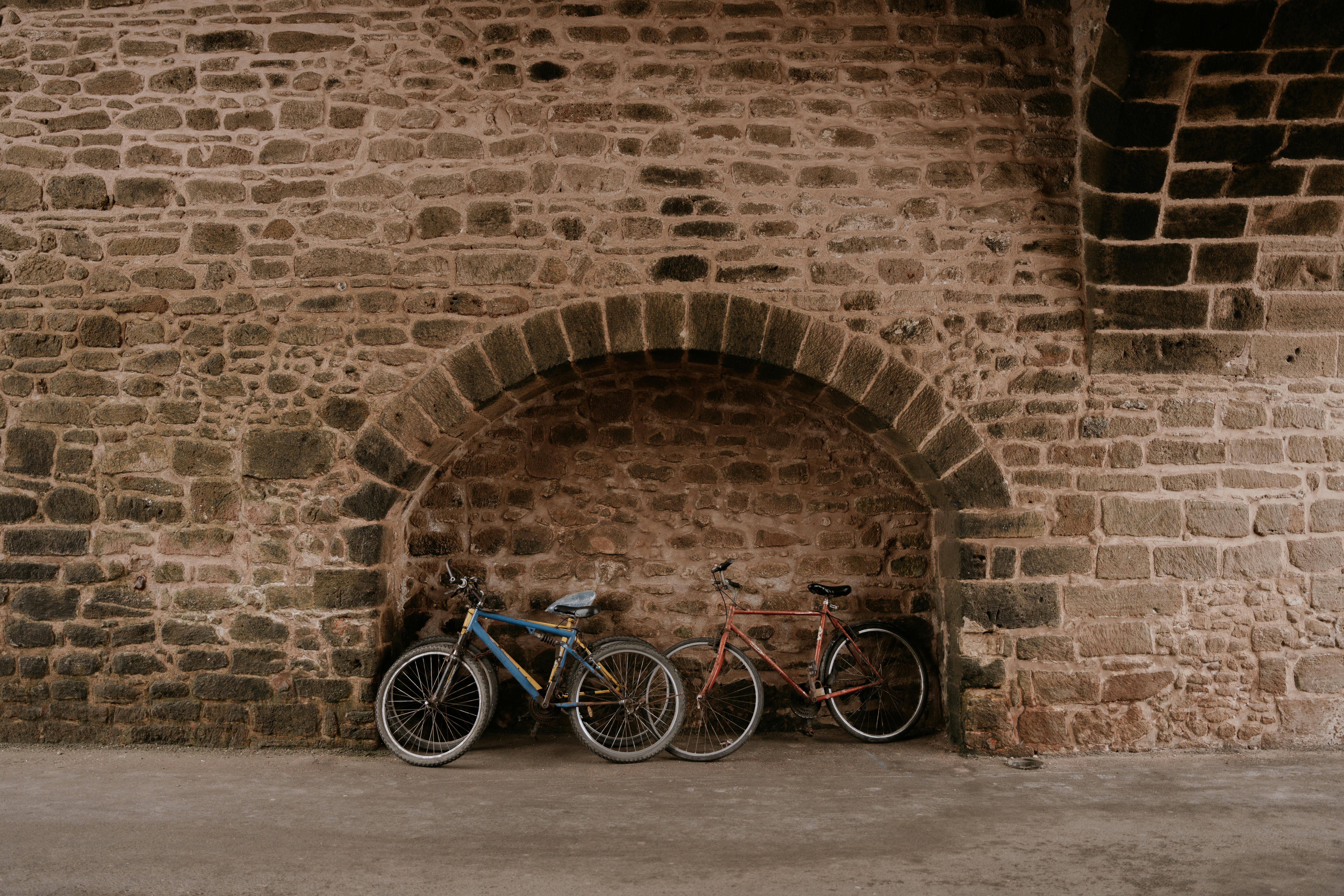 Vintage Bicycles Against Rustic Brick Wall · Free Stock Photo