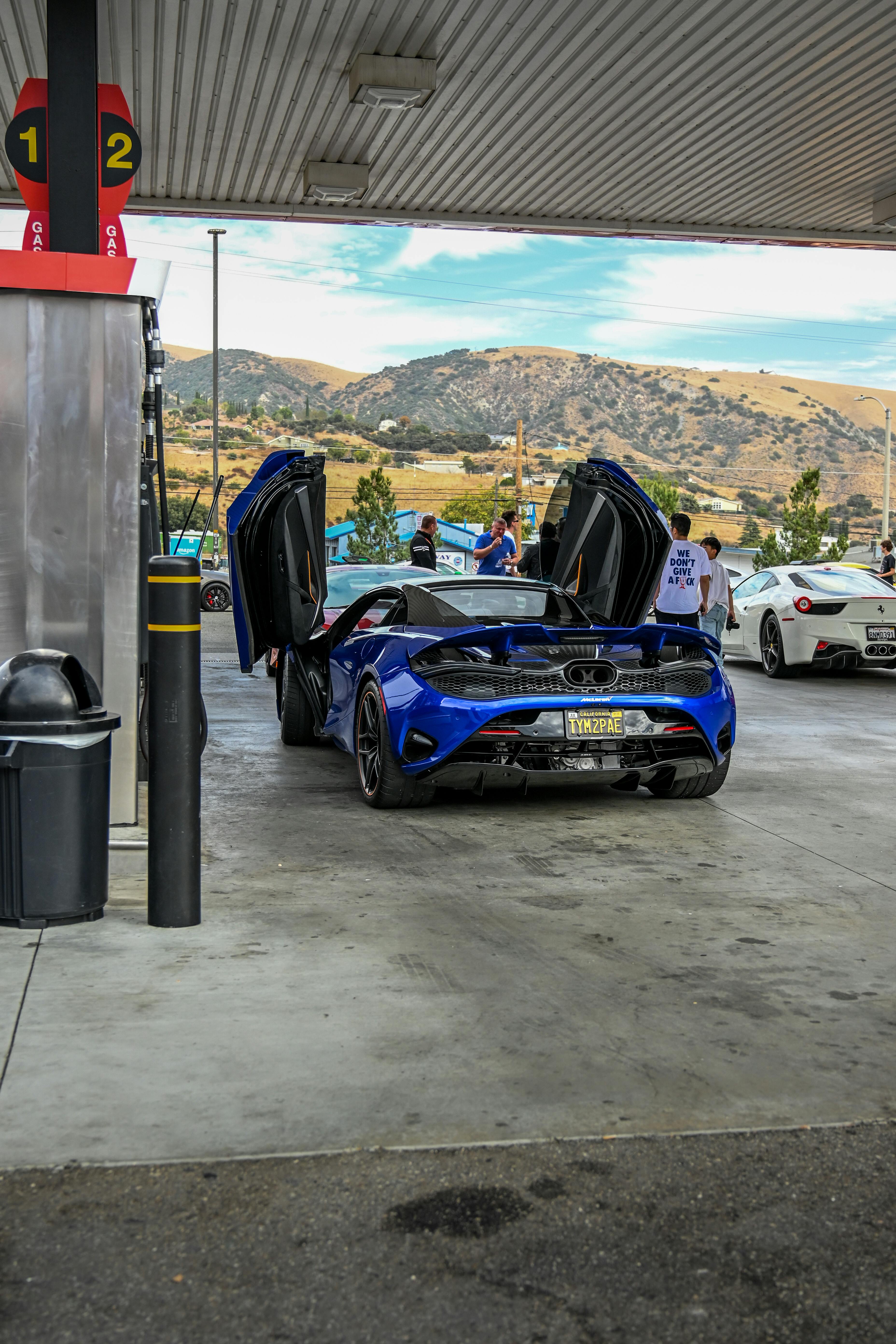 Luxury sports cars at gas station meetup · Free Stock Photo