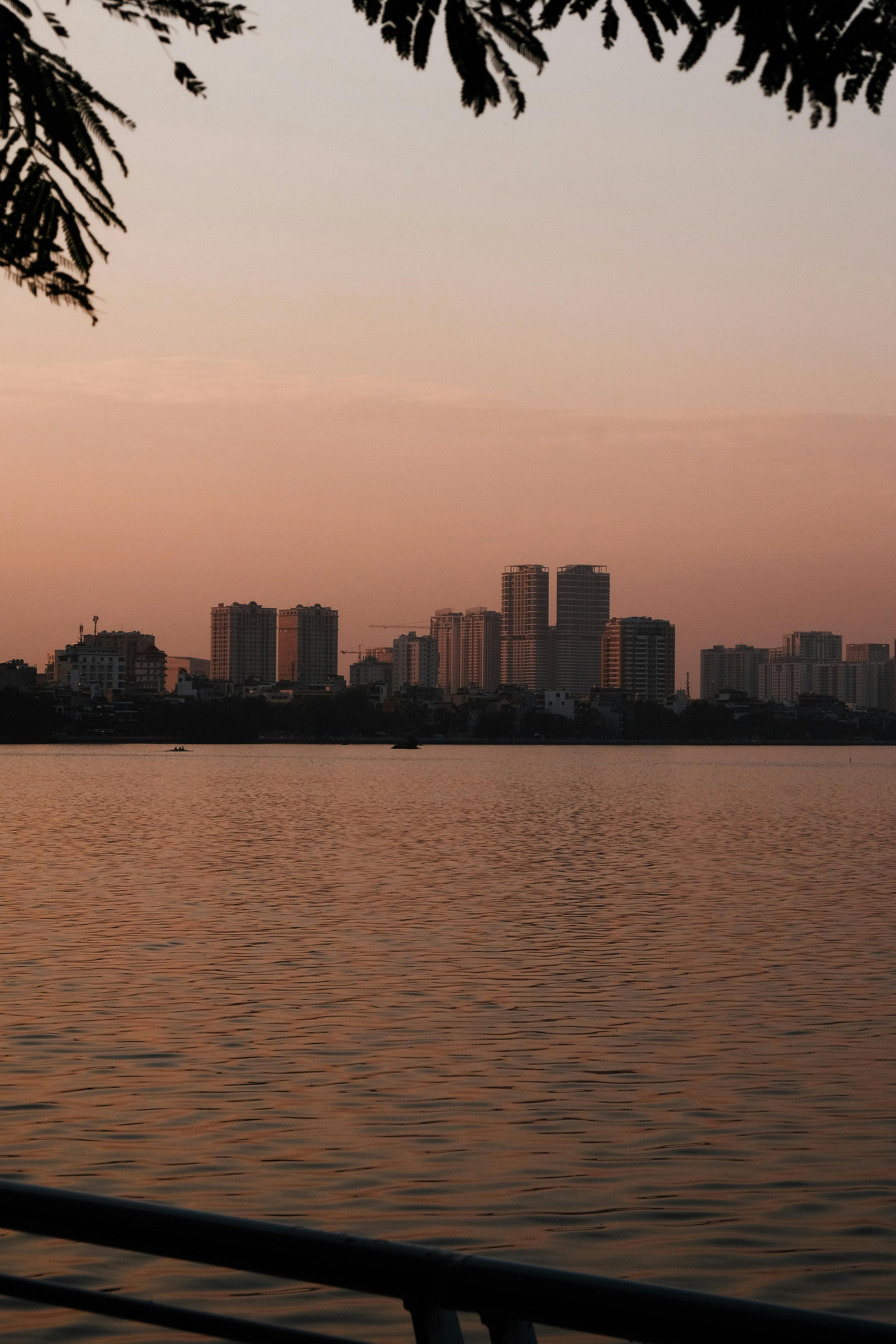 Scenic Urban Skyline at Sunset with Lake View · Free Stock Photo
