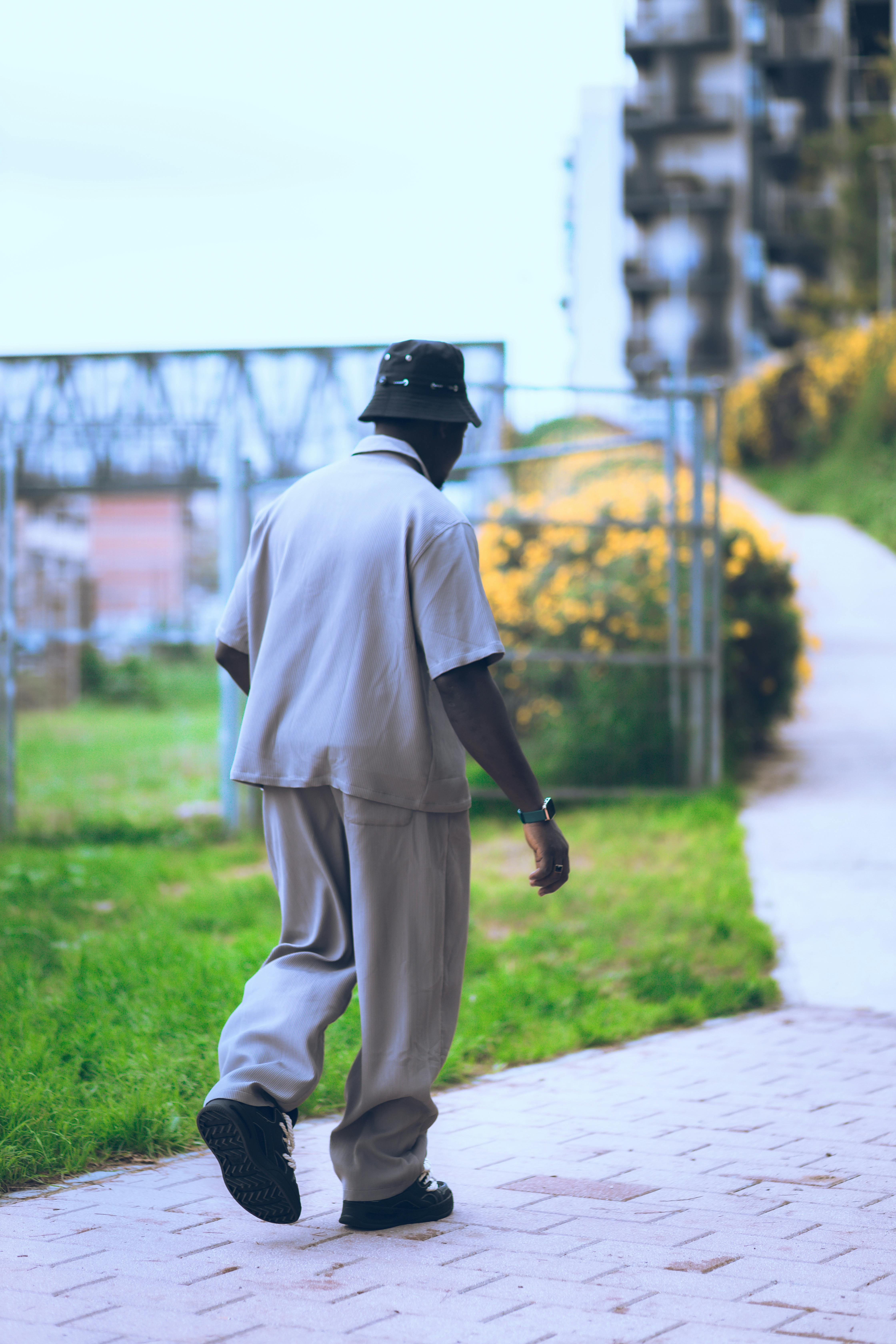 Man Walking on Sidewalk in Urban Environment · Free Stock Photo