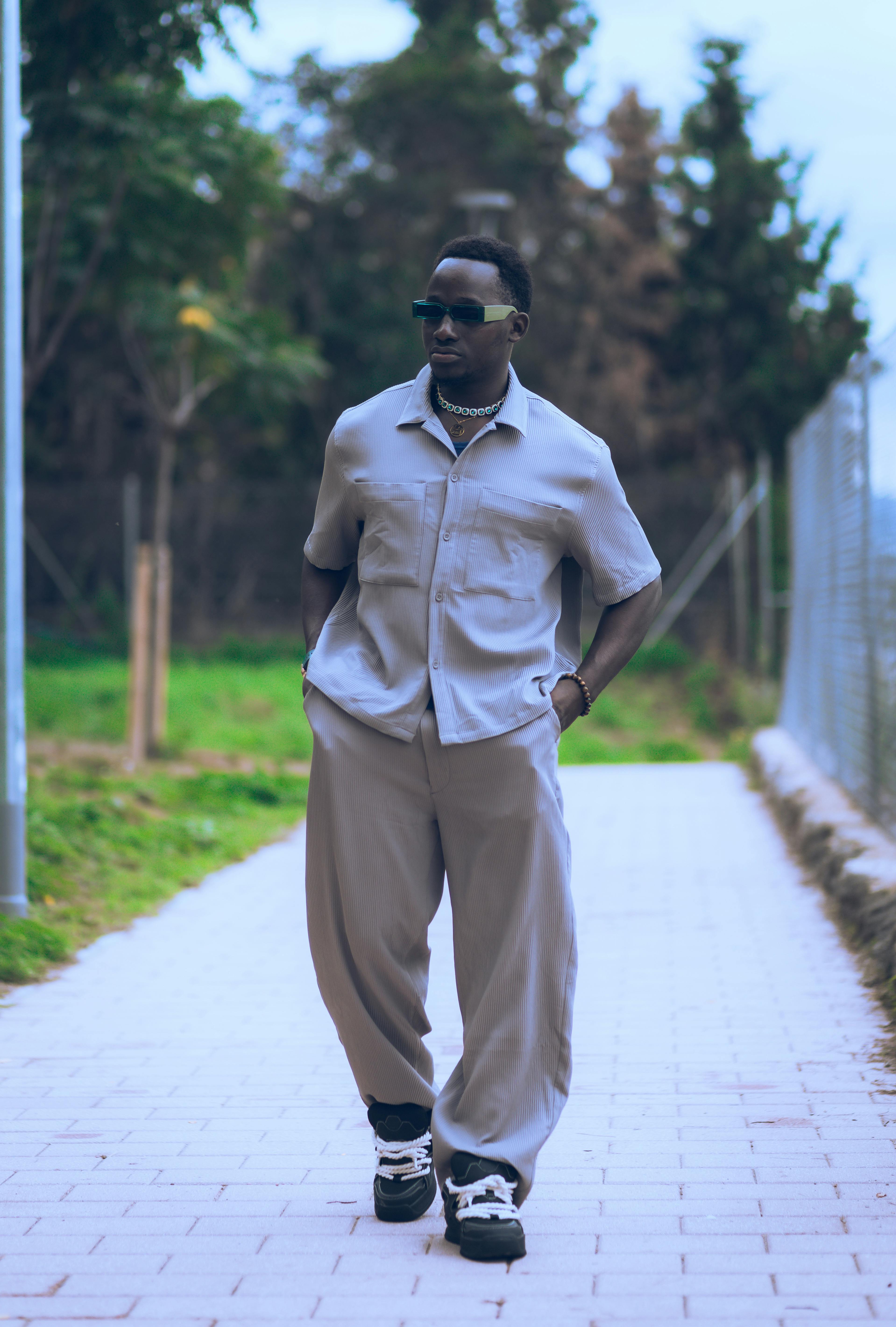 Stylish man walking confidently on park path · Free Stock Photo