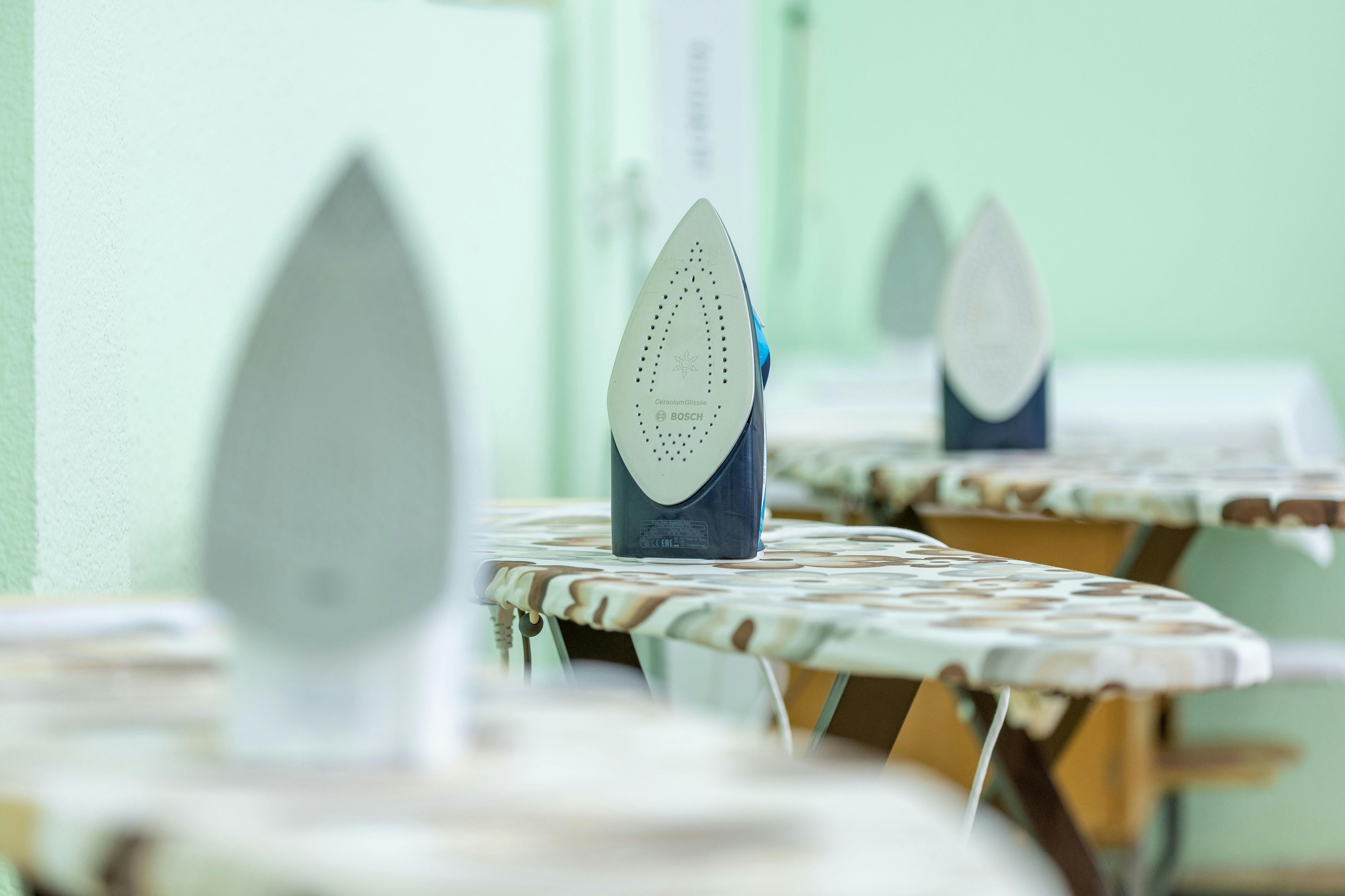 Modern Irons Aligned on Camouflage Pattern Boards · Free Stock Photo