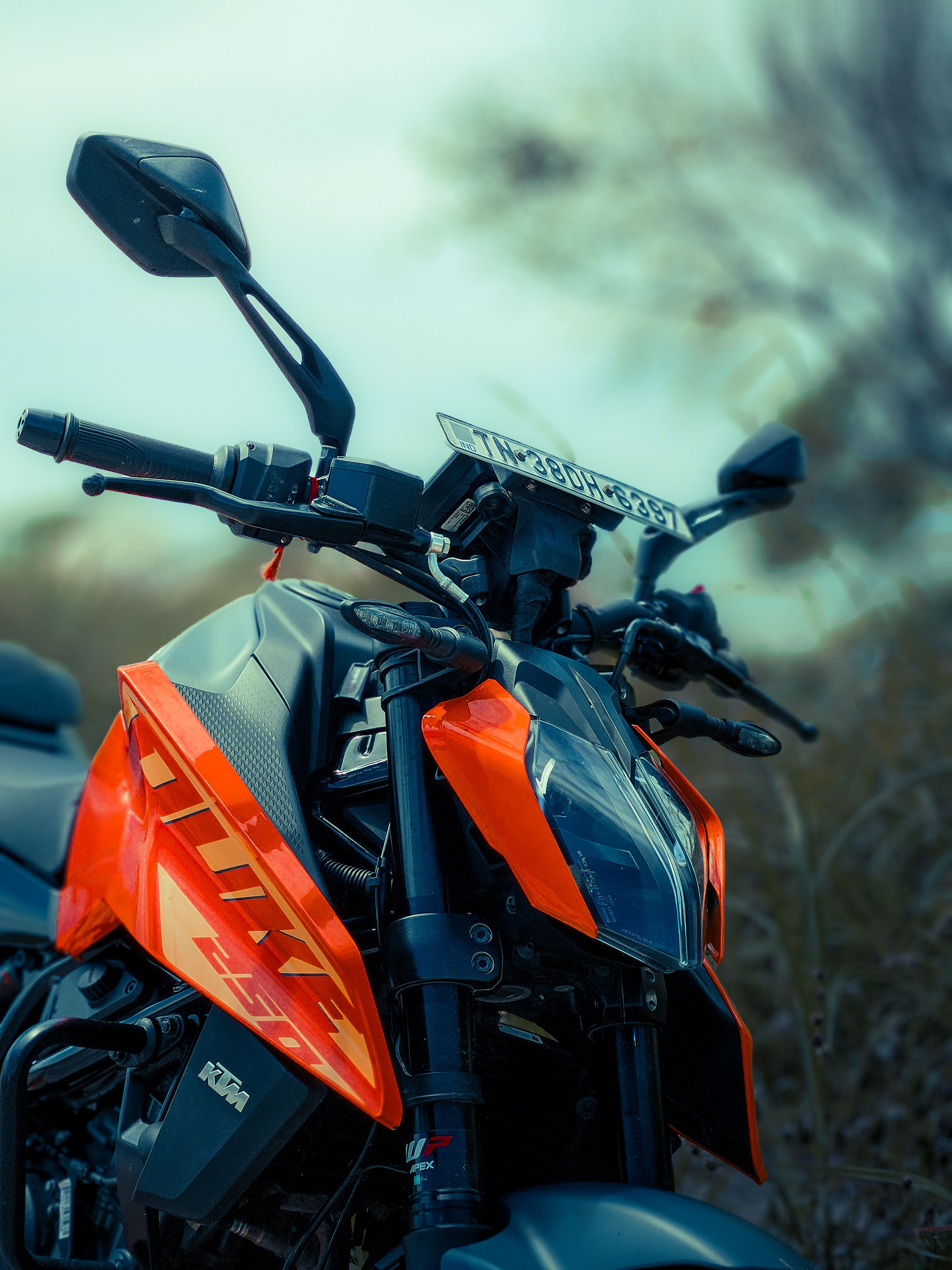 Vibrant Orange Motorcycle in Nature Setting · Free Stock Photo