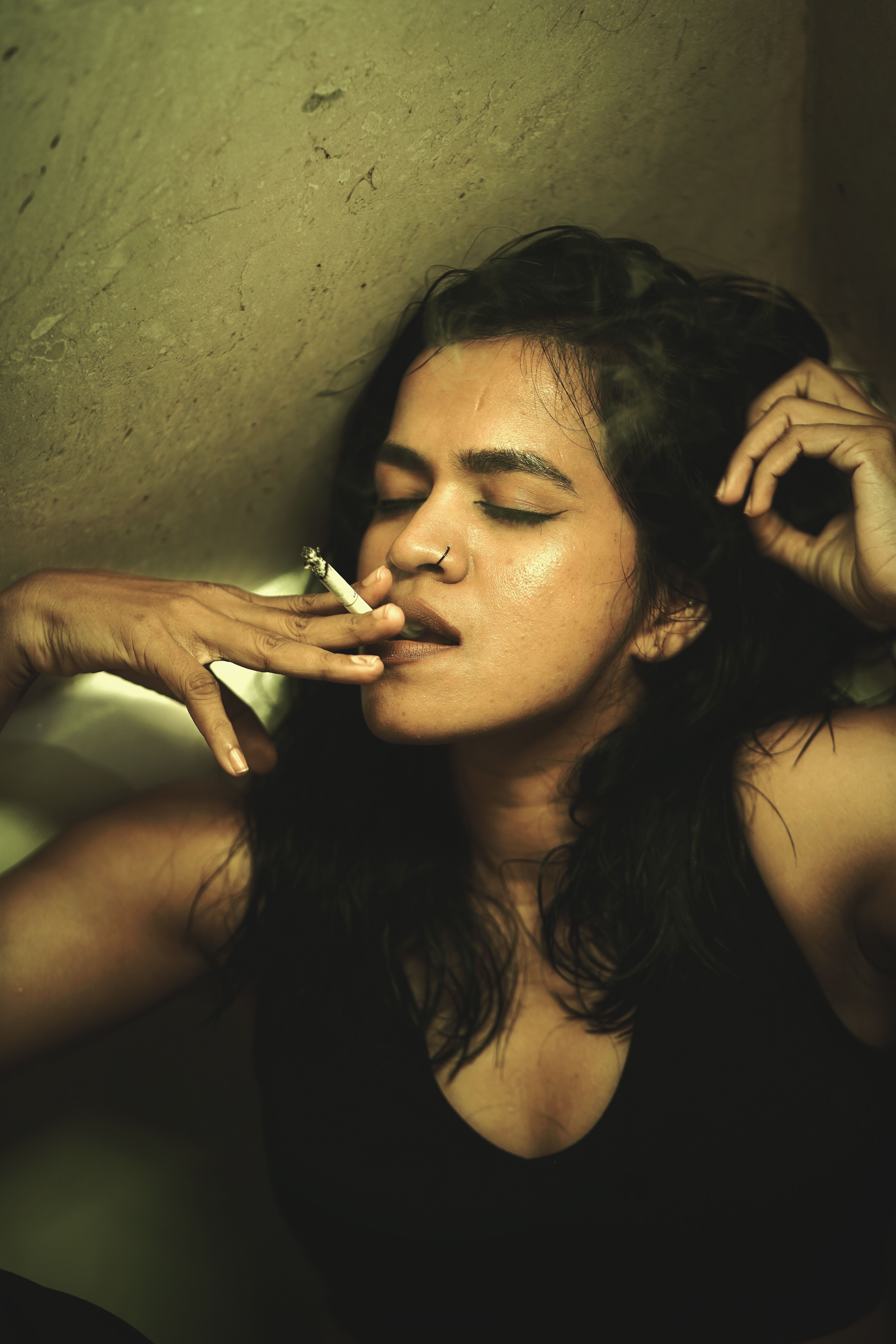 Moody Portrait of Woman Smoking Indoors · Free Stock Photo