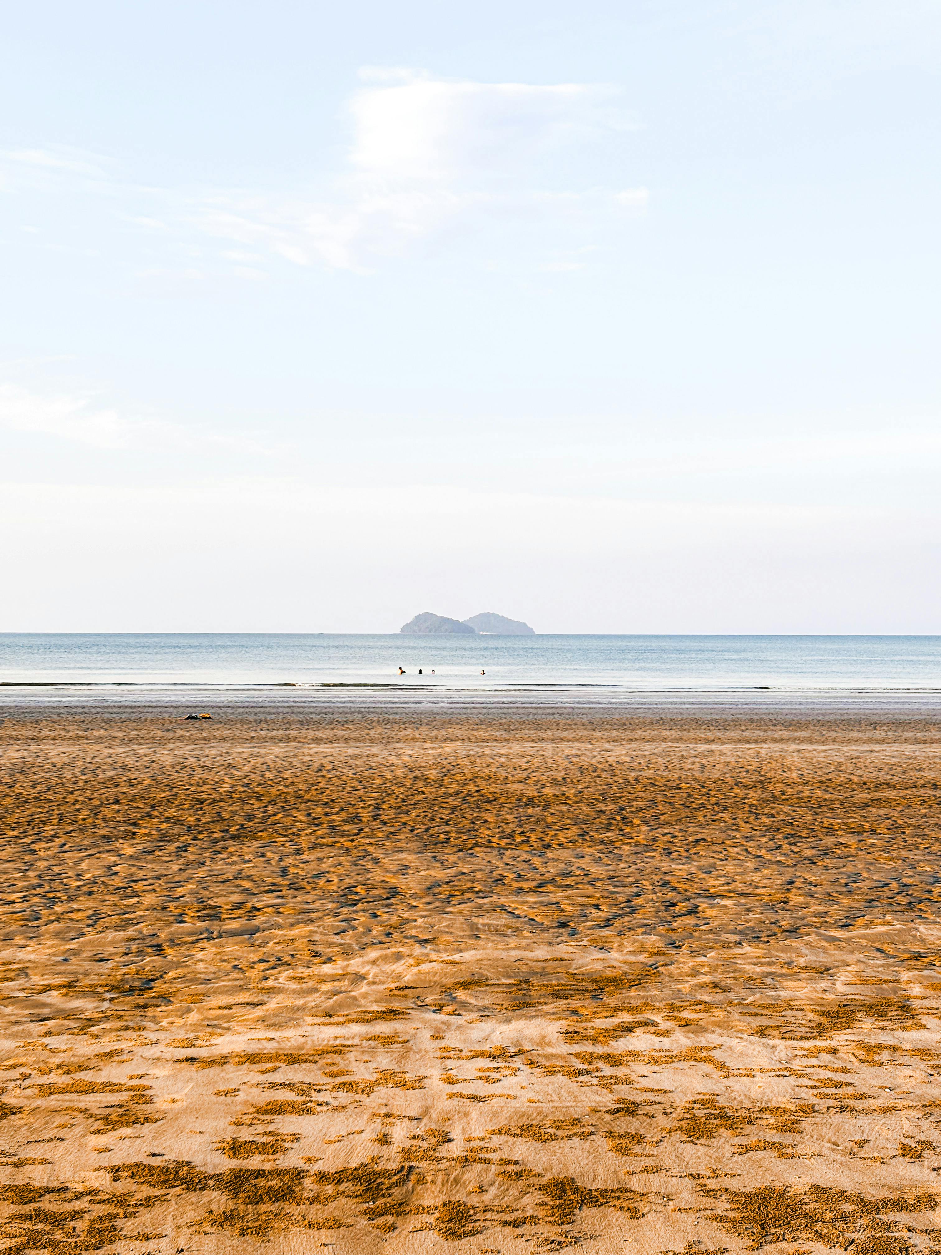 Serene Beachfront with Distant Island View · Free Stock Photo