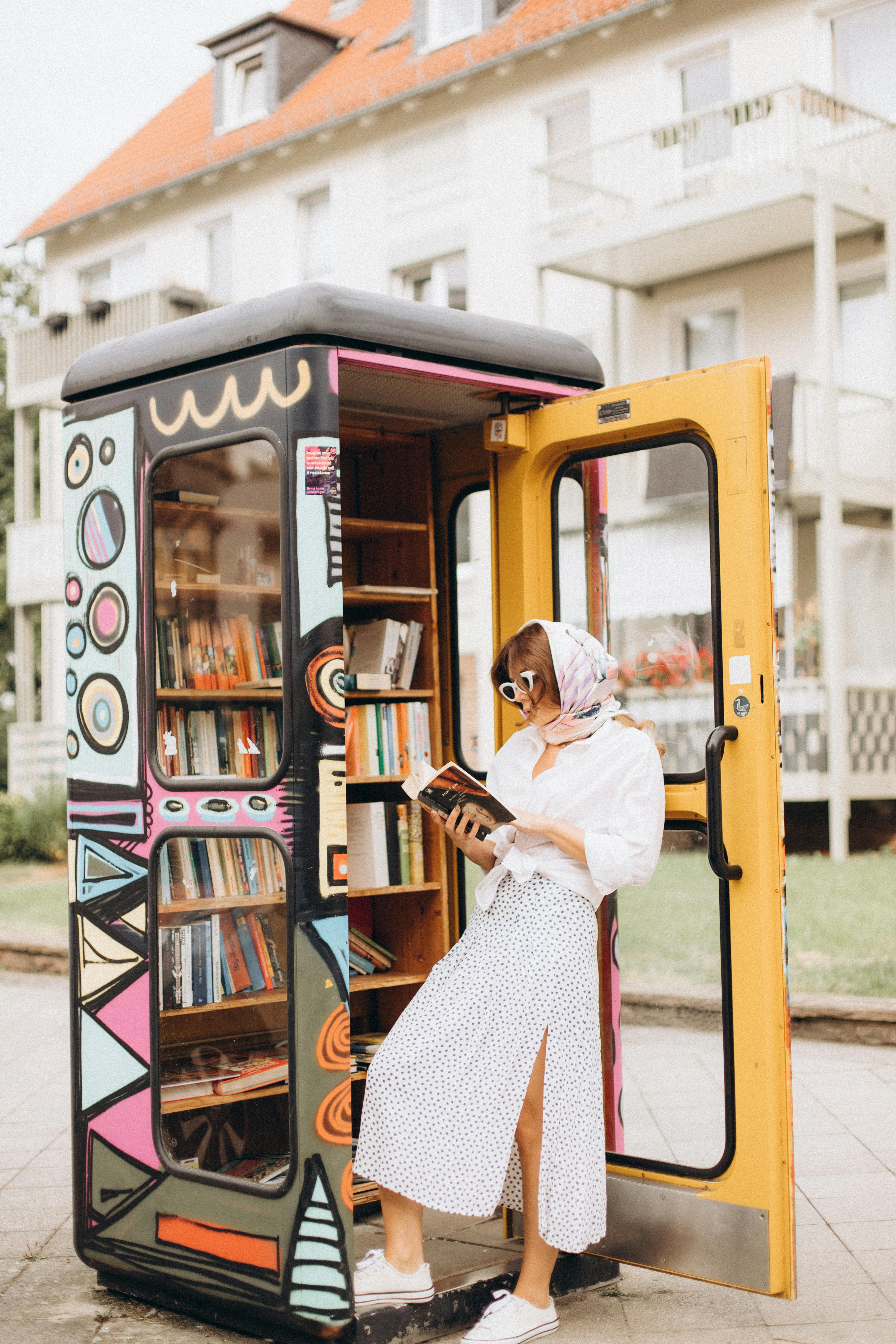 Stylish Woman Reading at Vibrant Outdoor Library · Free Stock Photo