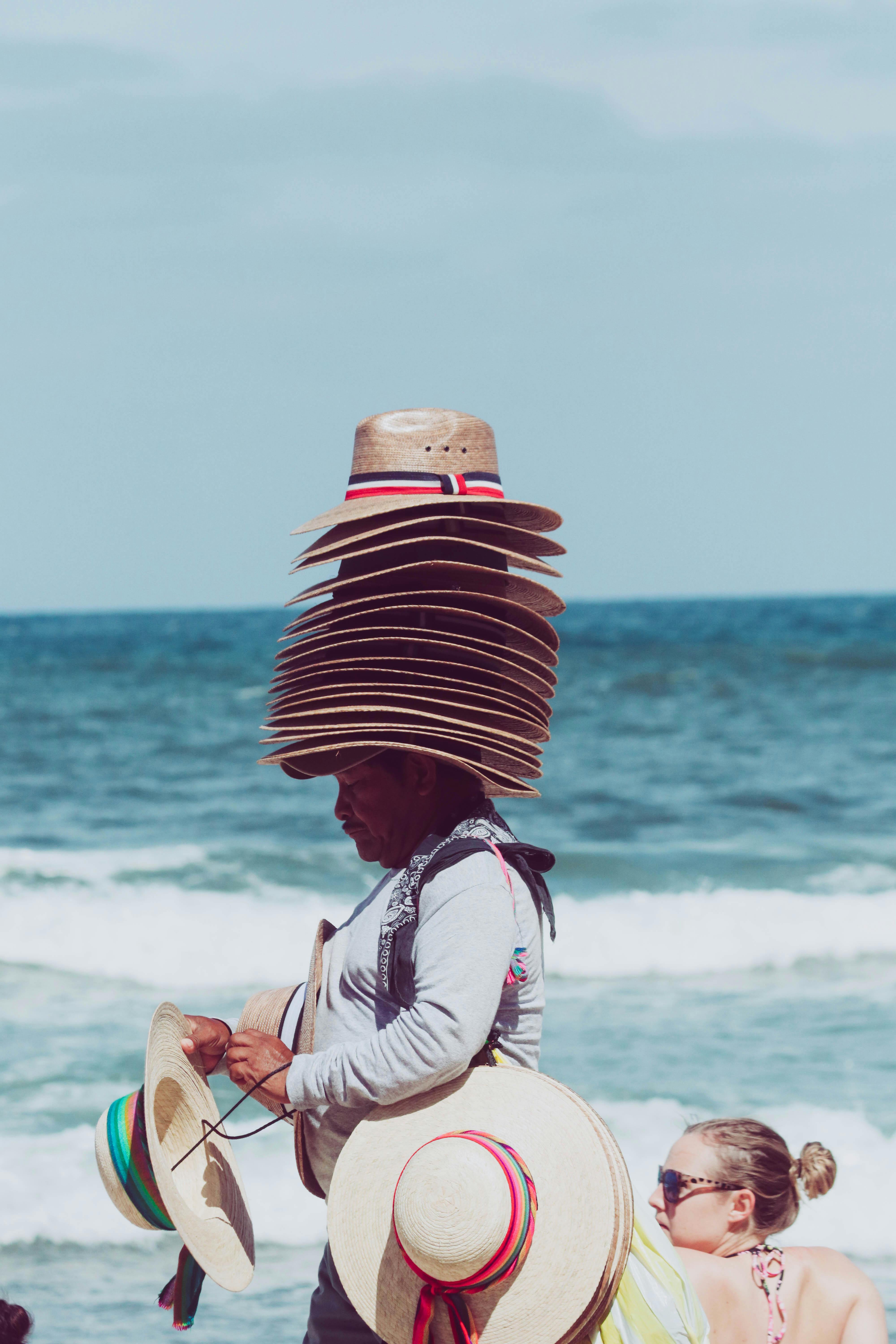 Street Vendor Selling Hats on a Tropical Beach · Free Stock Photo