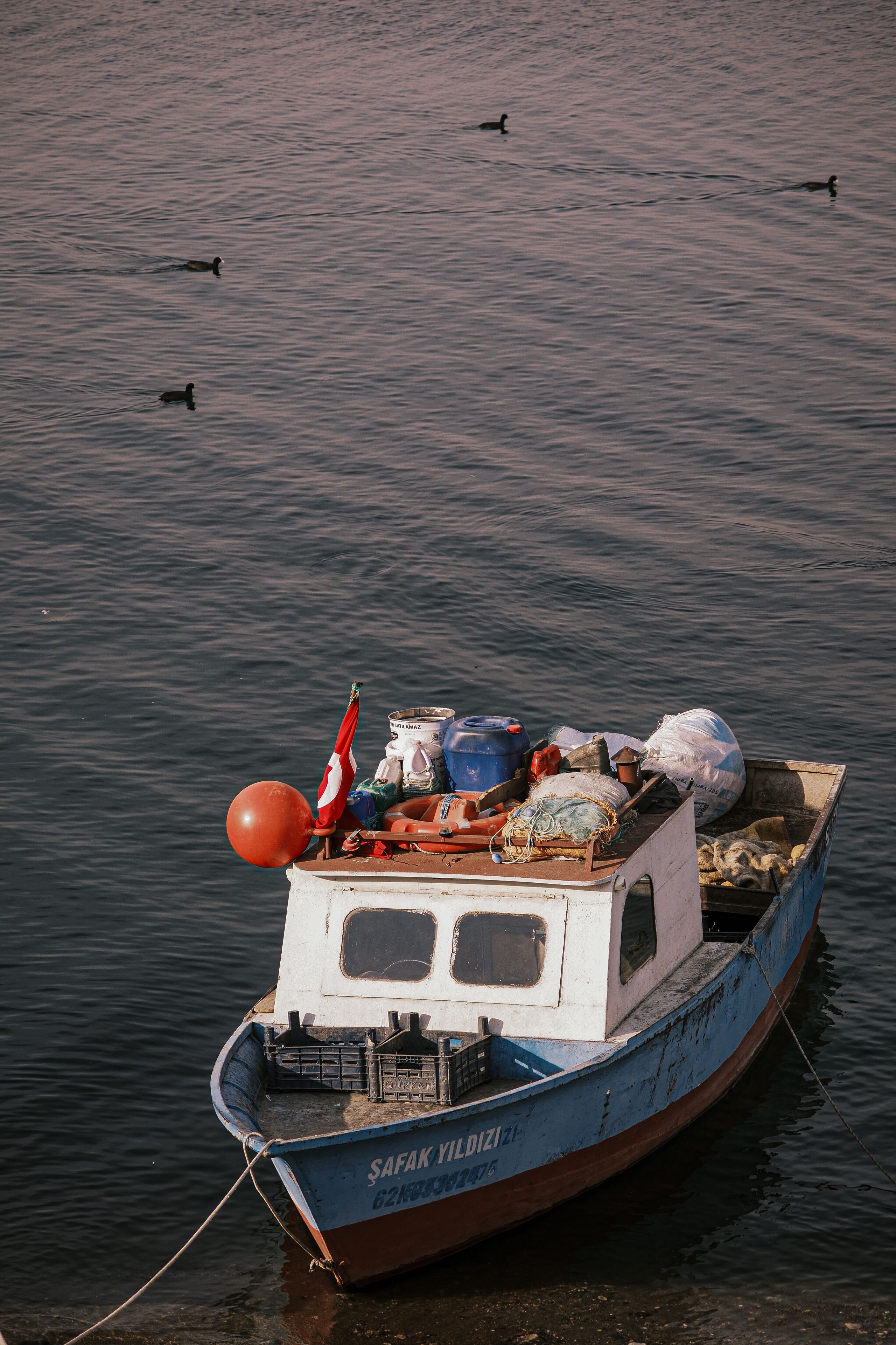 Small Fishing Boat Moored on Calm Waters · Free Stock Photo