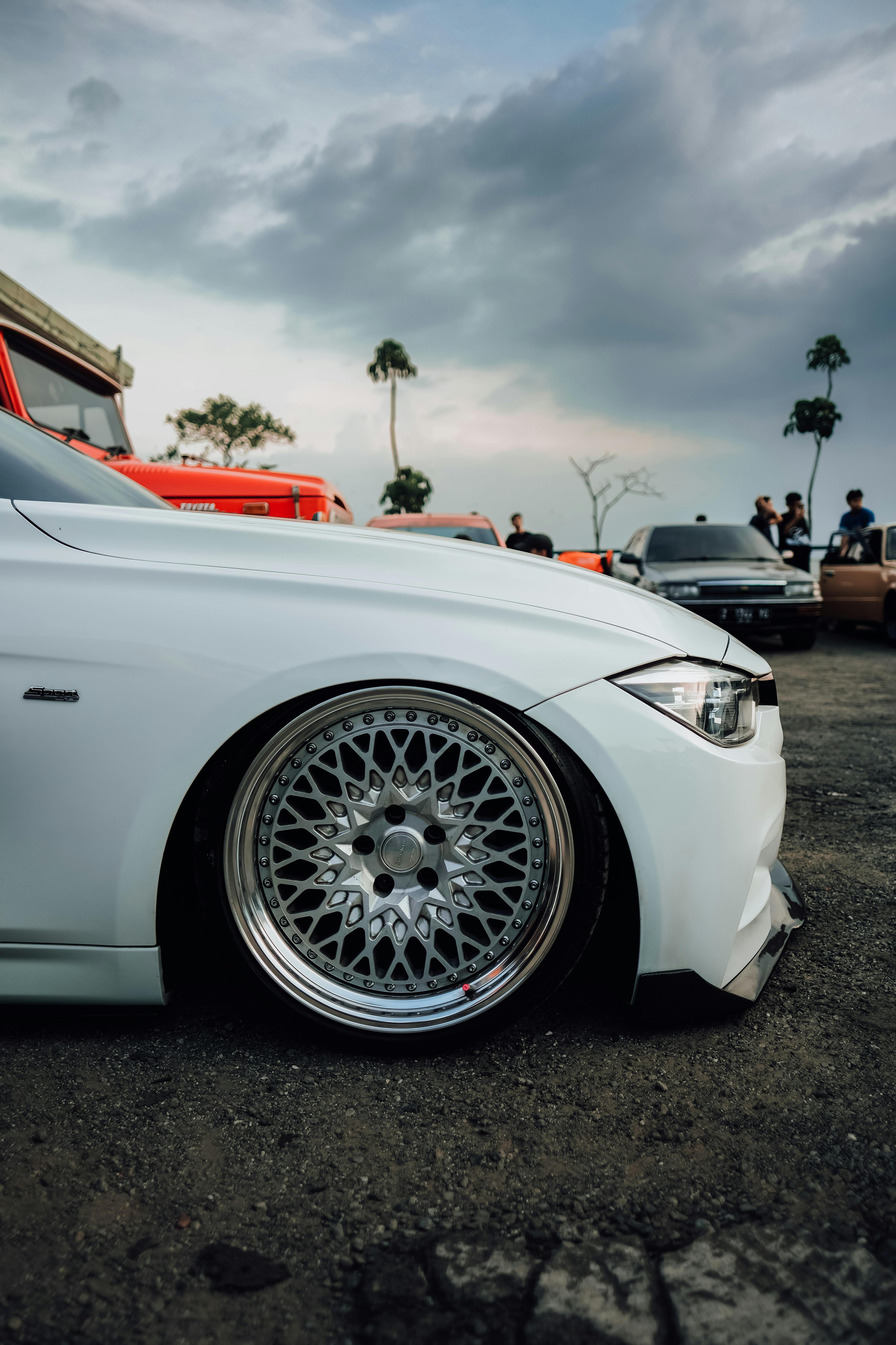 Sleek White Car with Custom Alloy Wheels Outdoors · Free Stock Photo