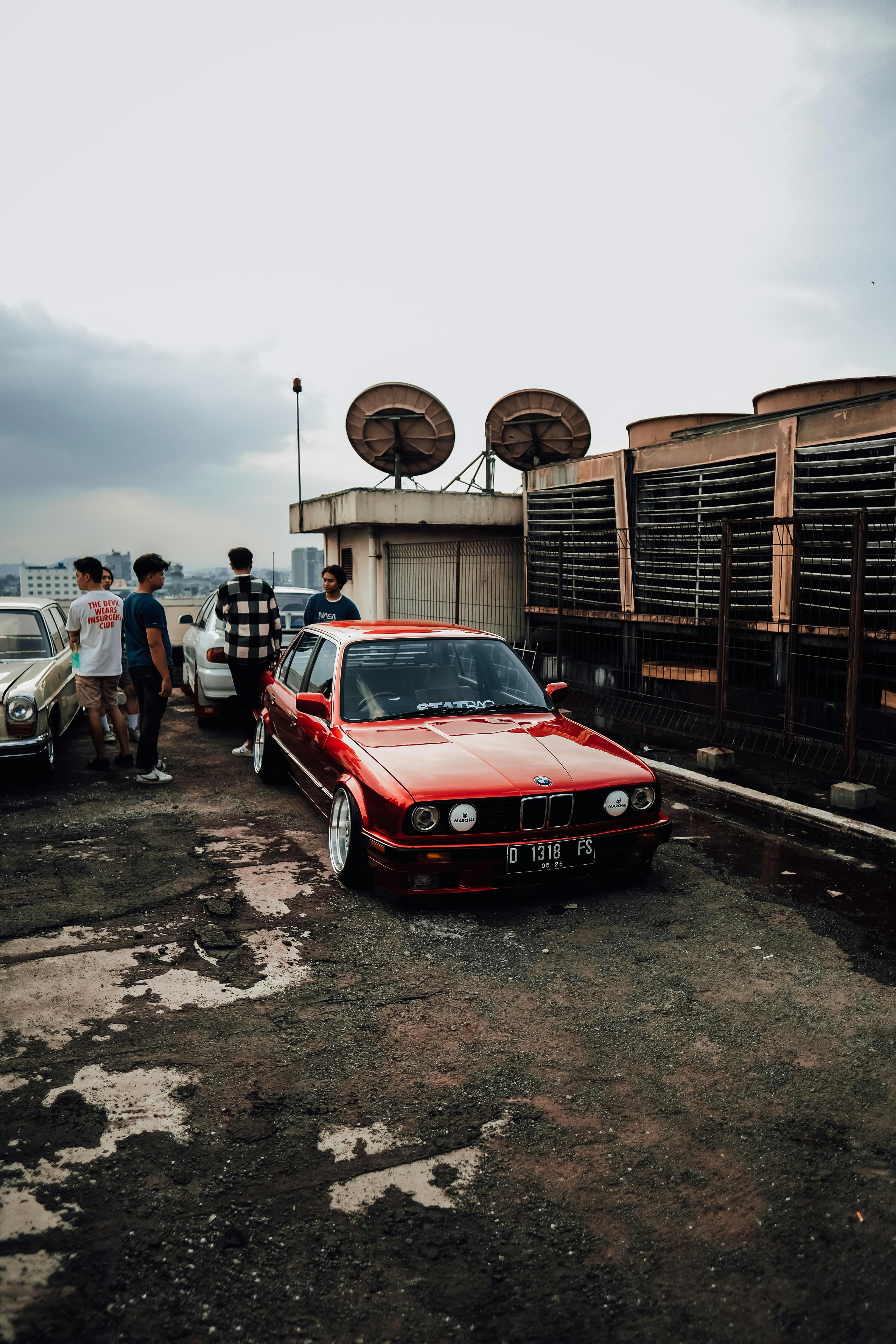 Urban Rooftop Car Meetup with Red Vintage Vehicle · Free Stock Photo