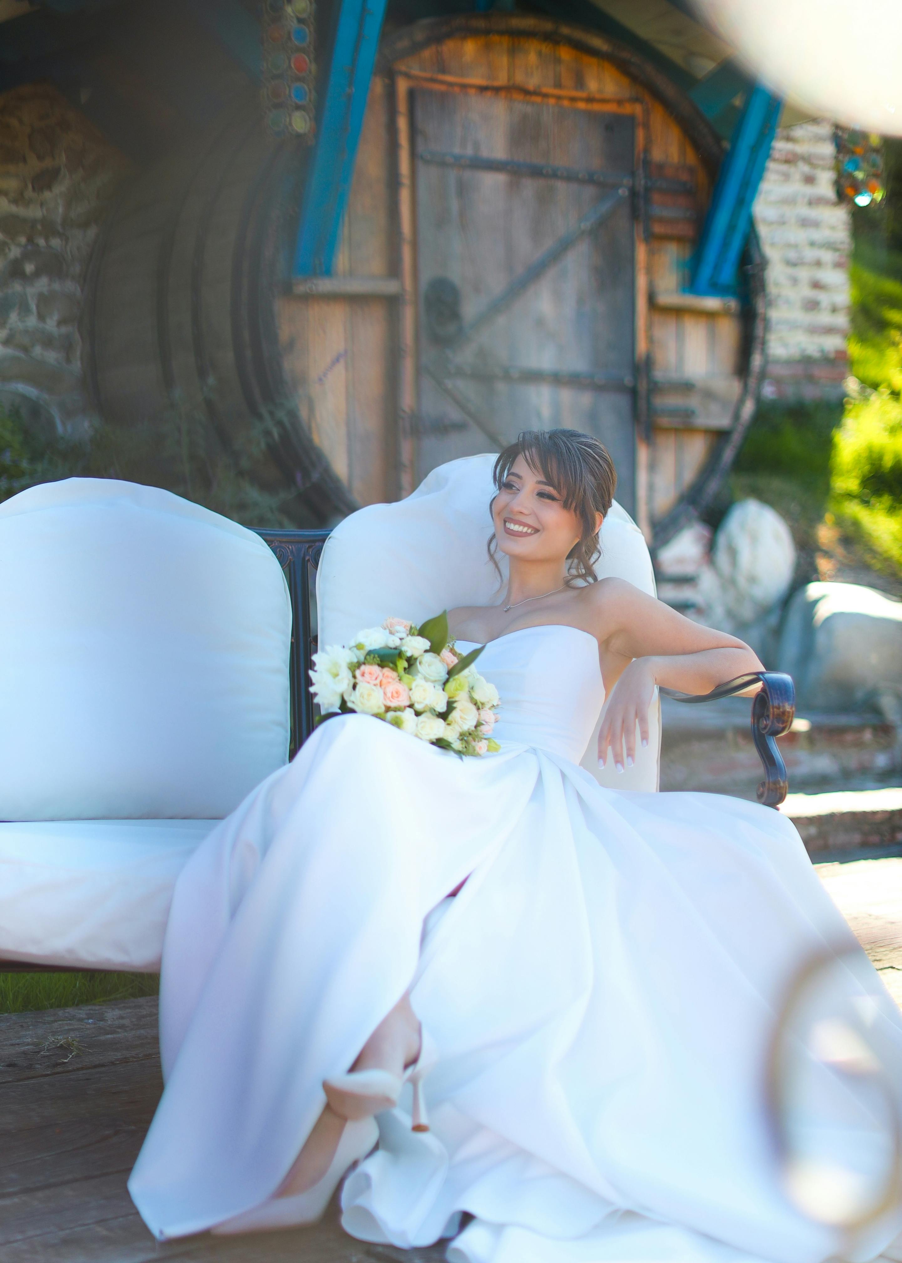 Bride Relaxing Outdoors with Bouquet · Free Stock Photo
