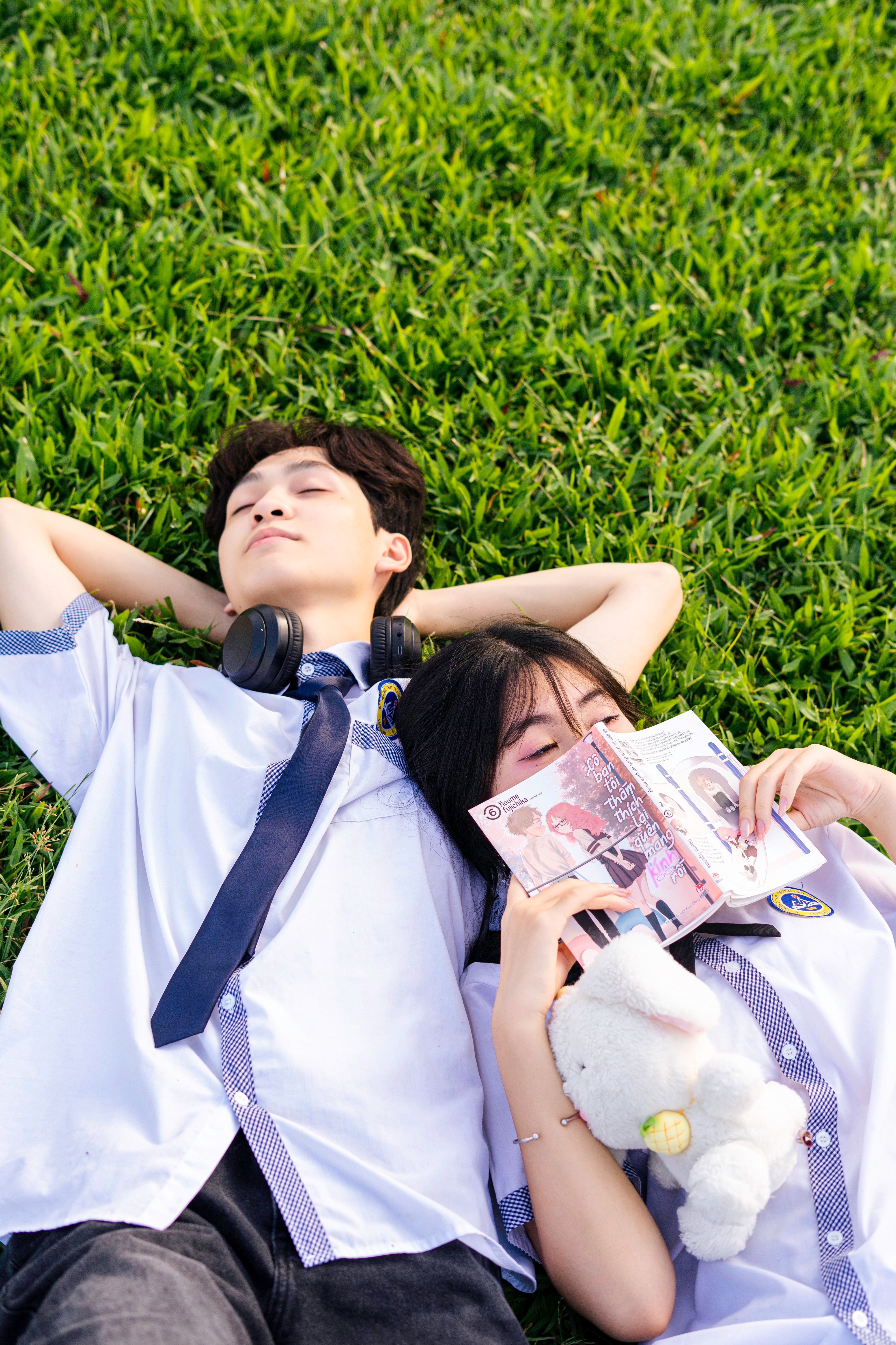 Teenagers Relaxing Outdoors on Grass Lawn · Free Stock Photo