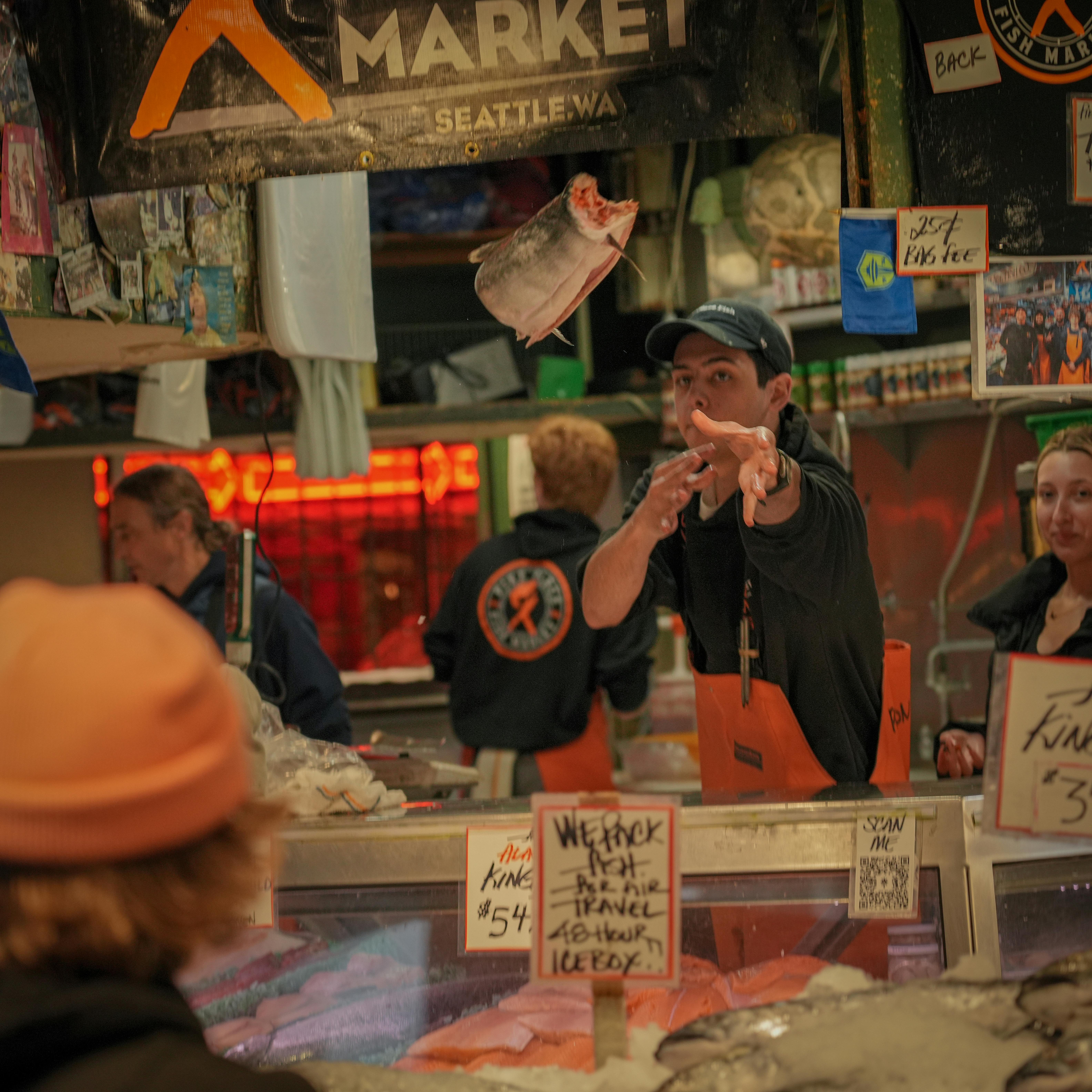 Fishmonger Throwing Fish at Seattle's Iconic Market · Free Stock Photo