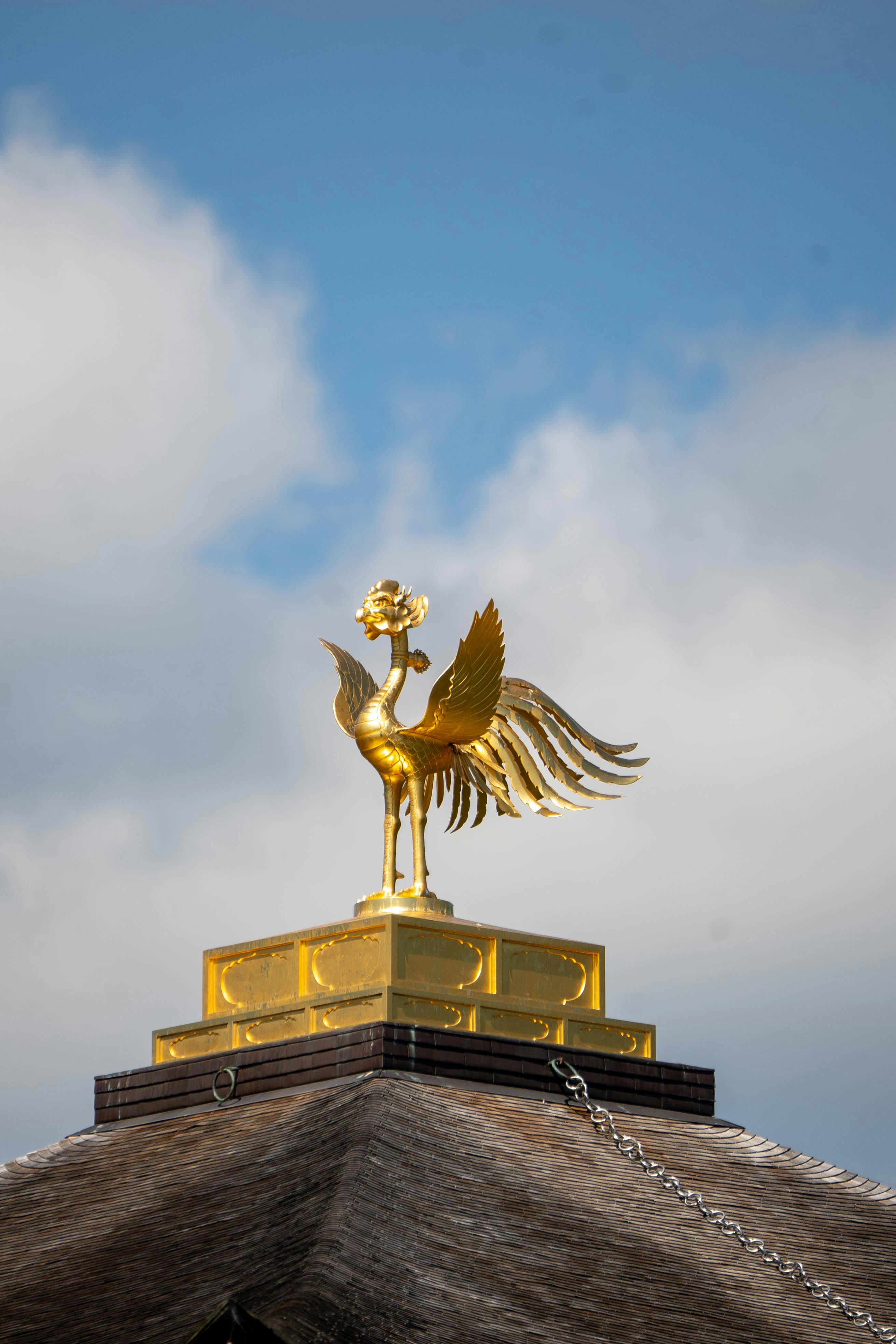 Golden Phoenix Statue on Roof Against Blue Sky · Free Stock Photo