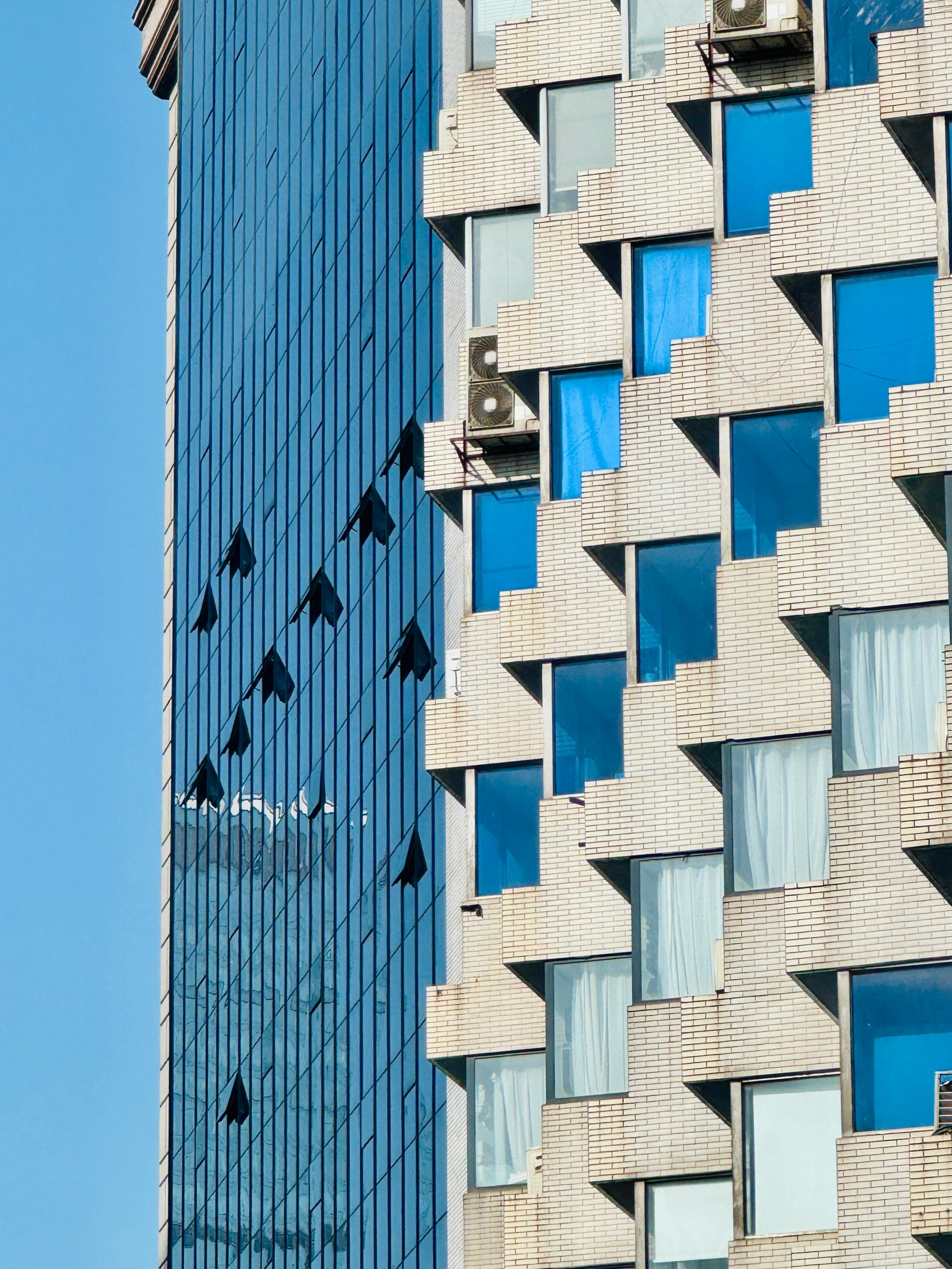 Modern skyscraper with geometric facade design · Free Stock Photo