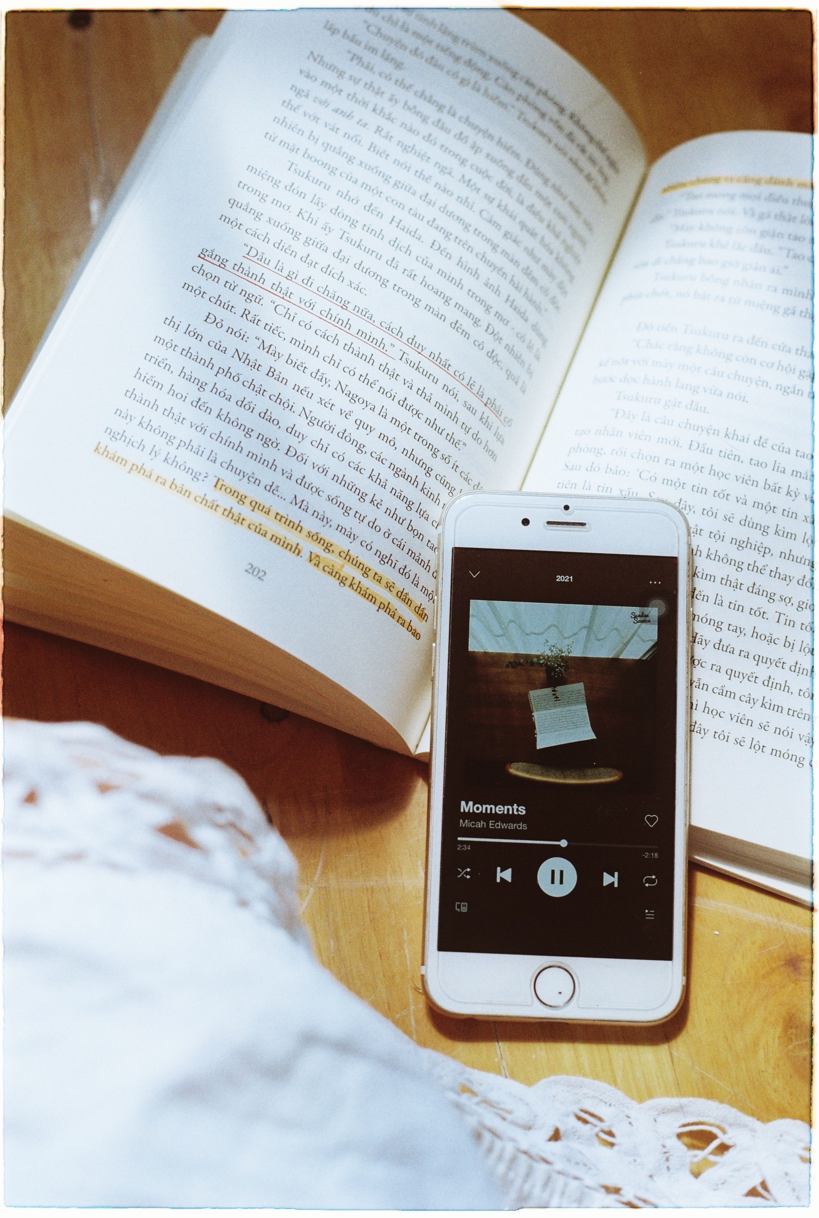 Open Book and Smartphone with Music App on Table · Free Stock Photo