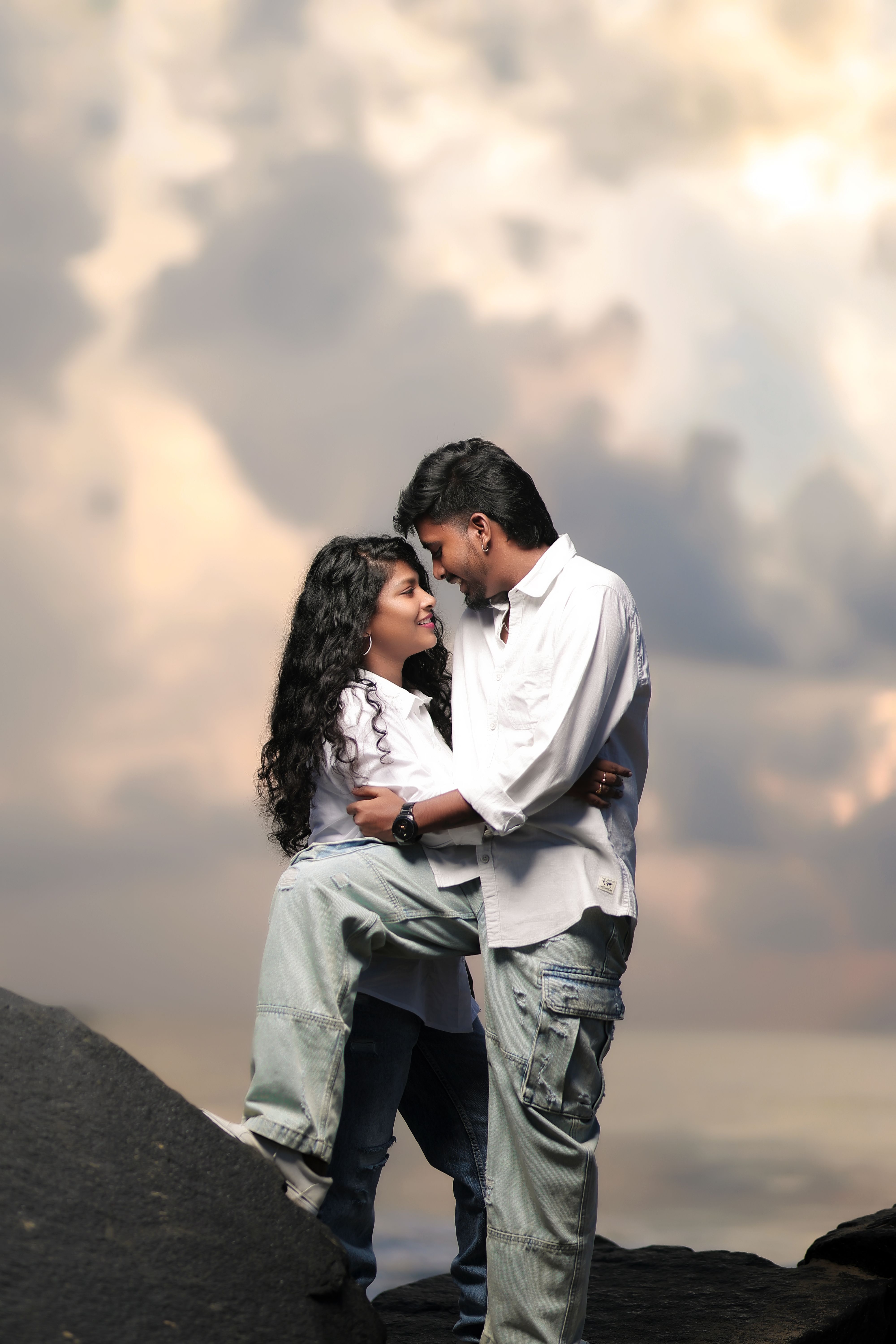 Romantic Couple Embrace Under Dramatic Sky · Free Stock Photo