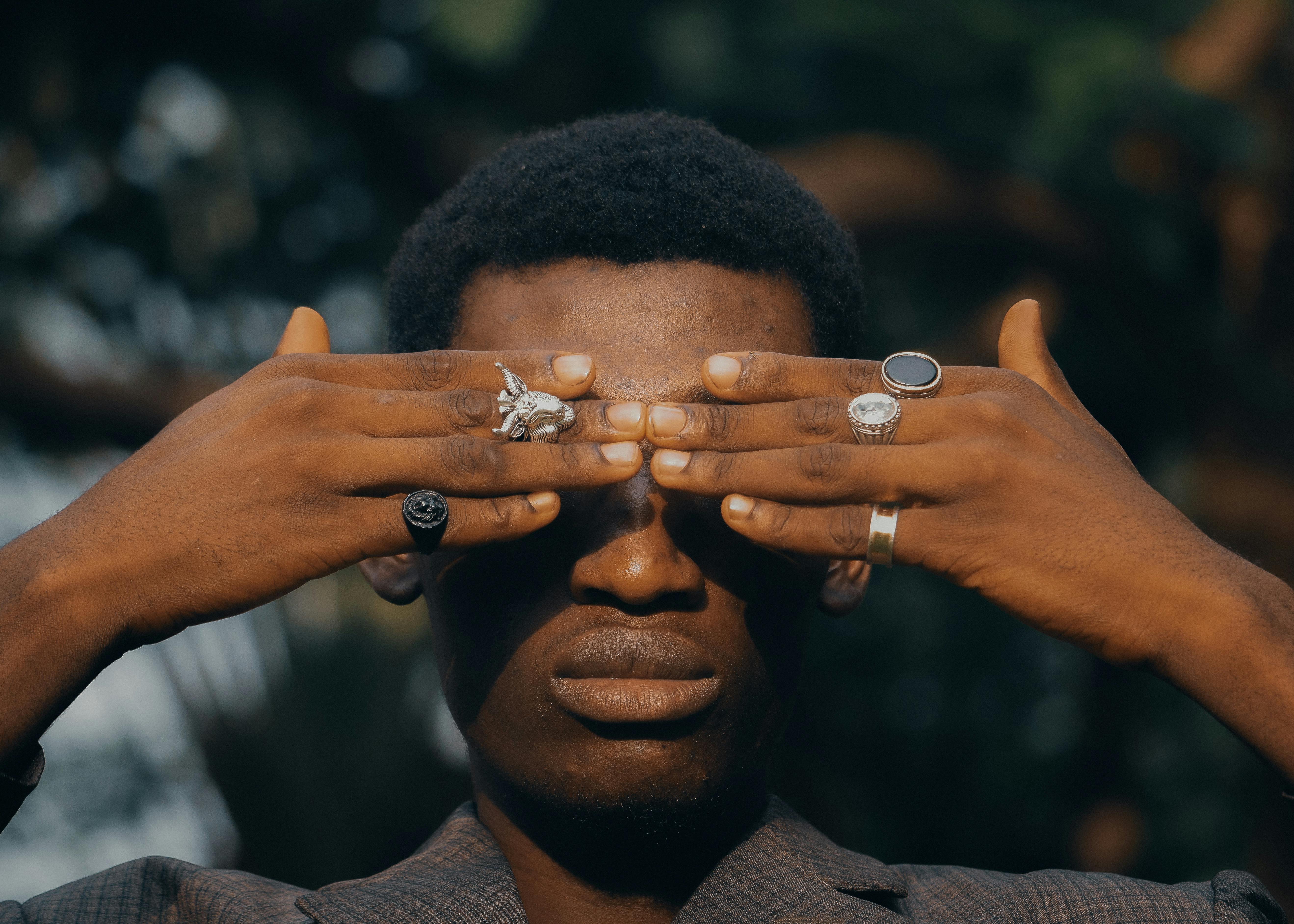 Close-Up Photo of a Man Covering His Face with His Hand with Rings ...