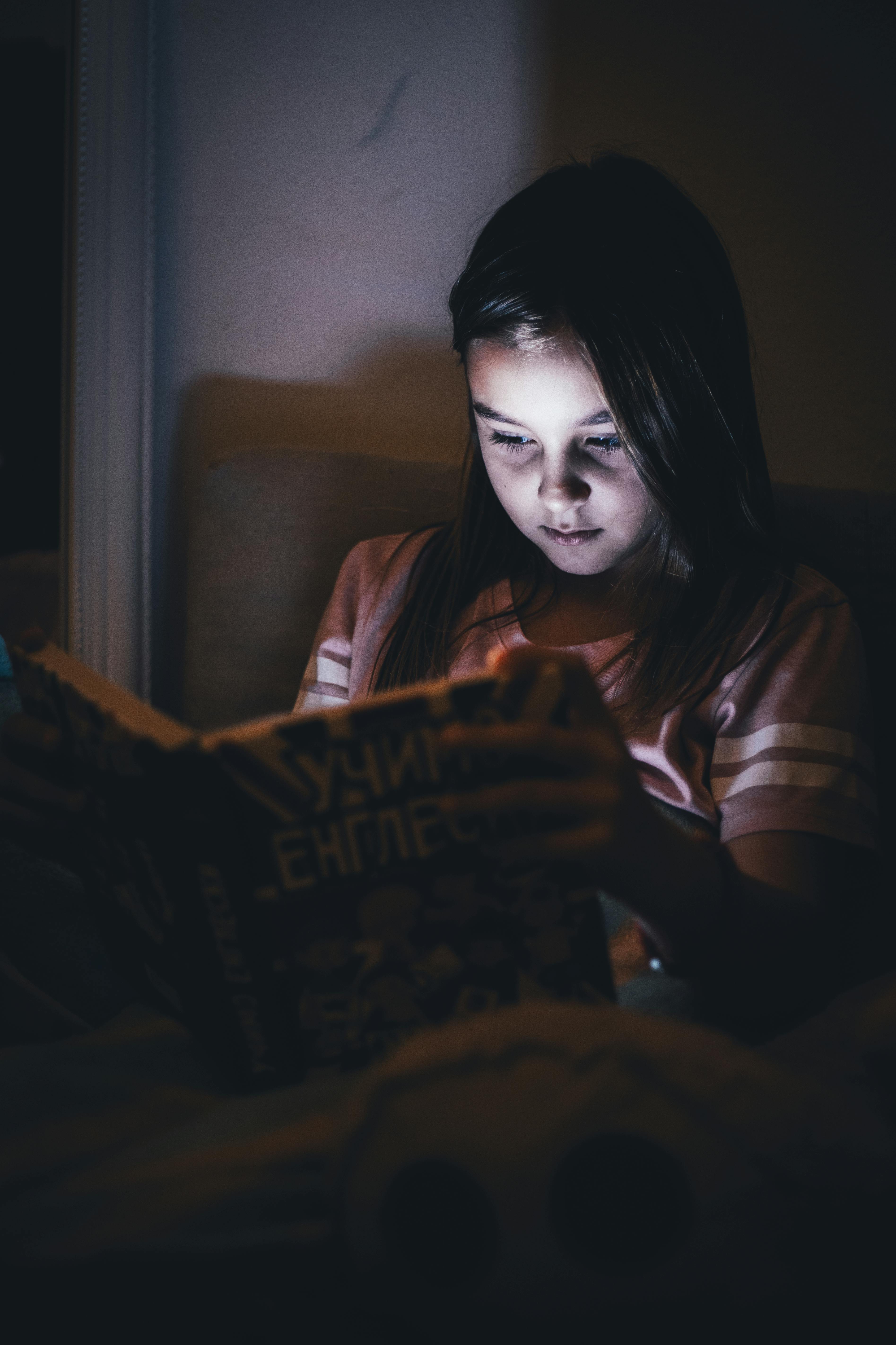 Young Girl Immersed in Nighttime Reading · Free Stock Photo