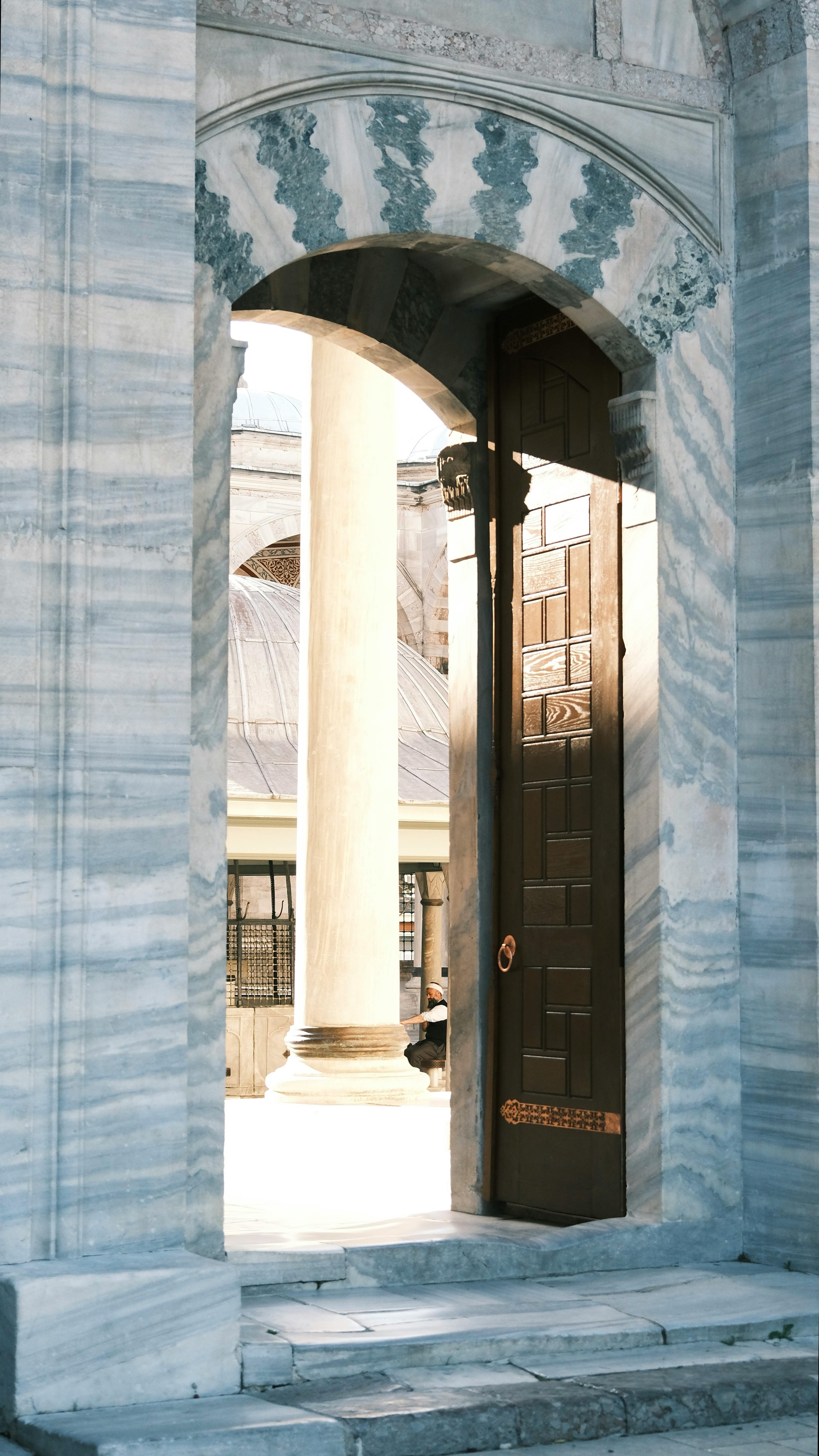 Ancient Marble Archway with Open Wooden Door · Free Stock Photo
