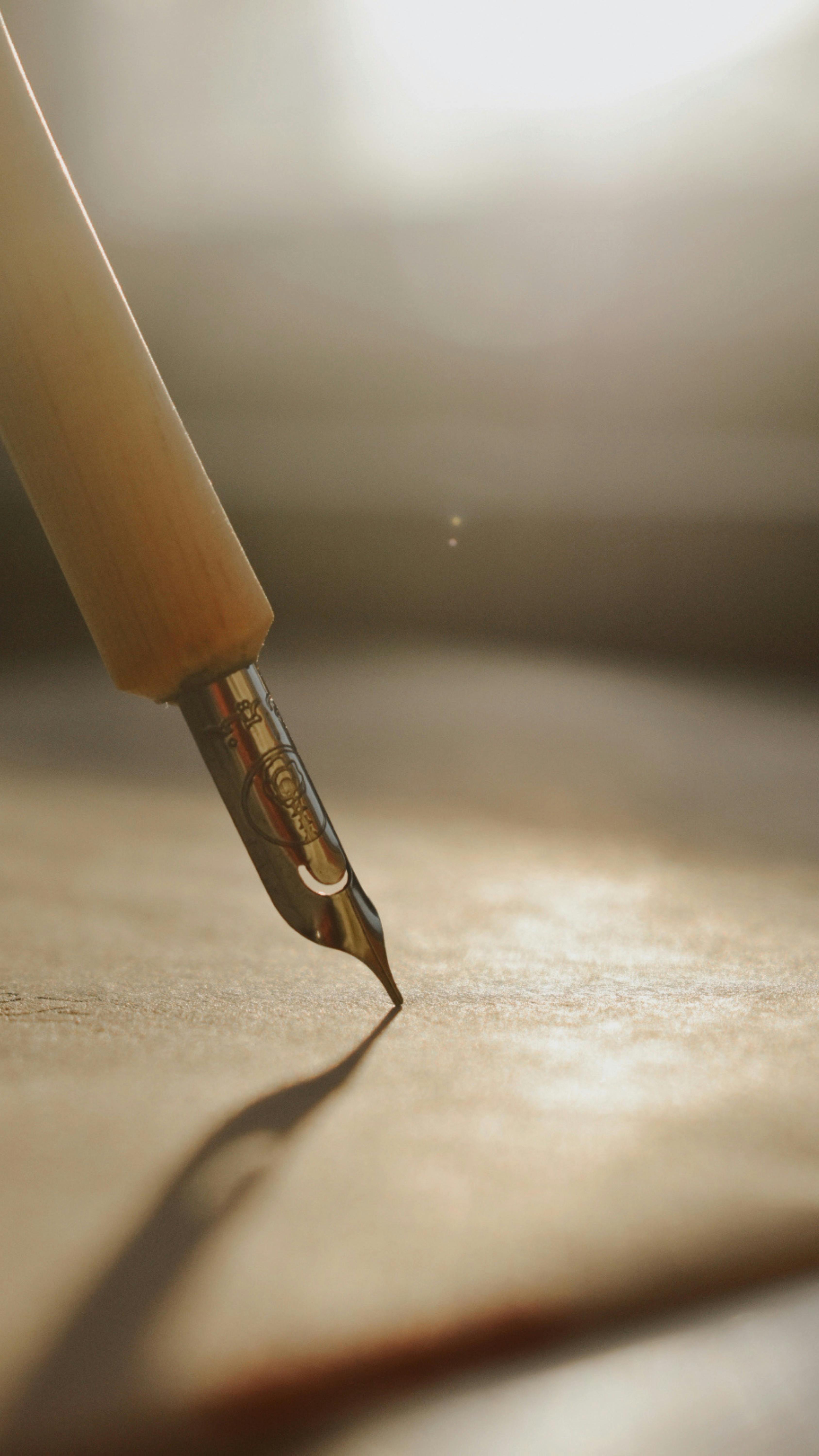 Elegant Fountain Pen Tip on Paper in Sunlit Scene · Free Stock Photo