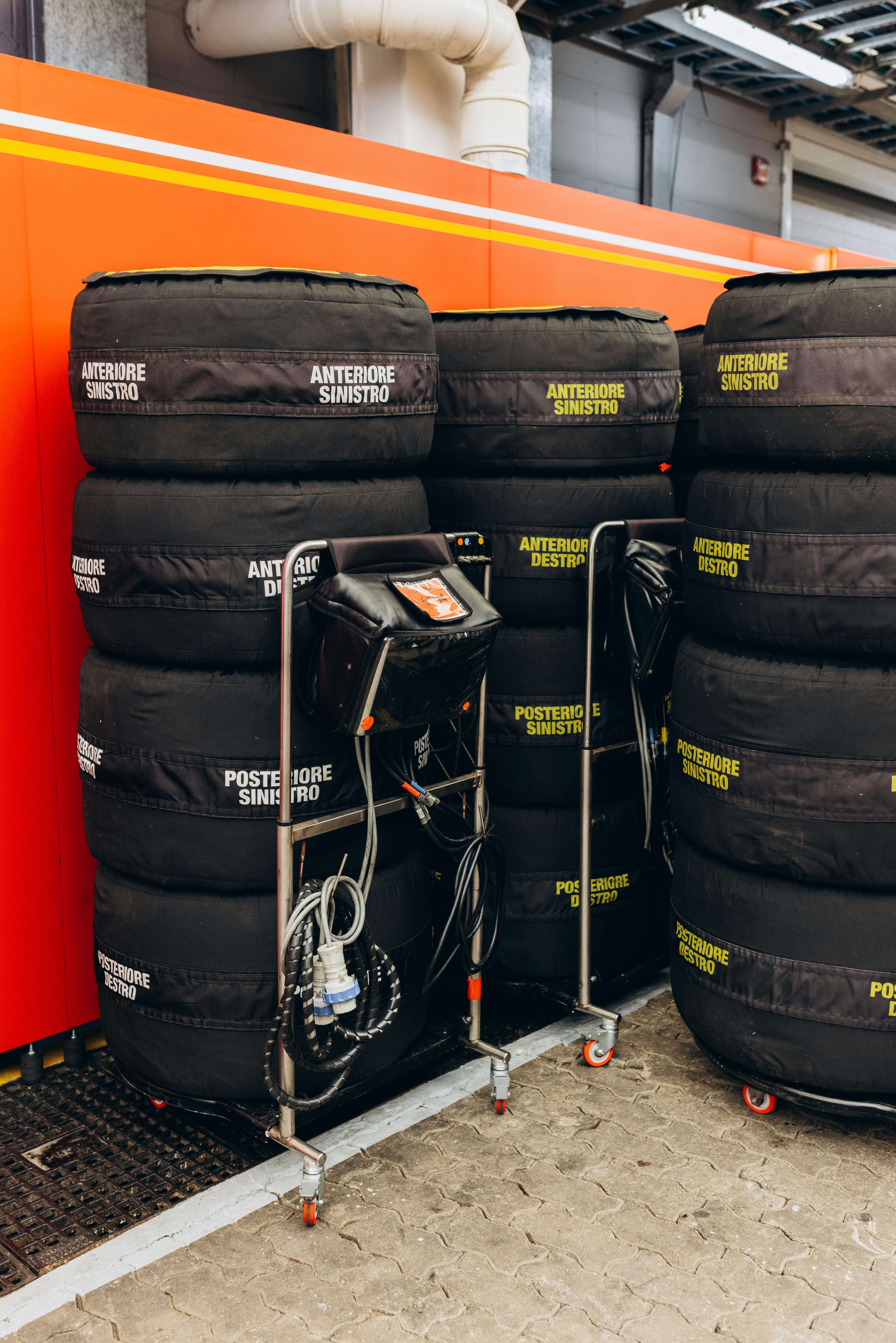 Stack of Racing Tires in a Garage Setting · Free Stock Photo