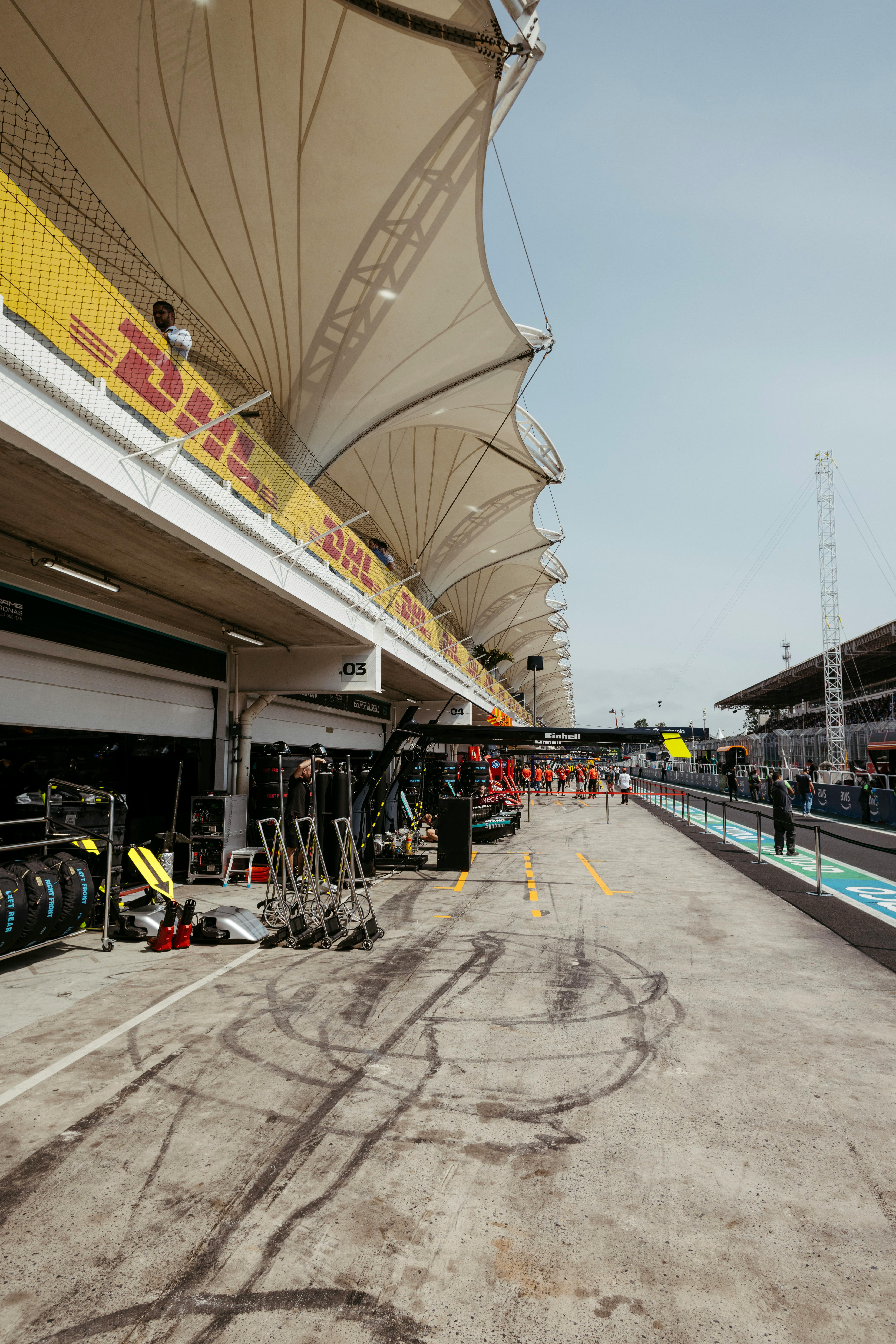 Busy Formula One Pit Lane with Tents · Free Stock Photo
