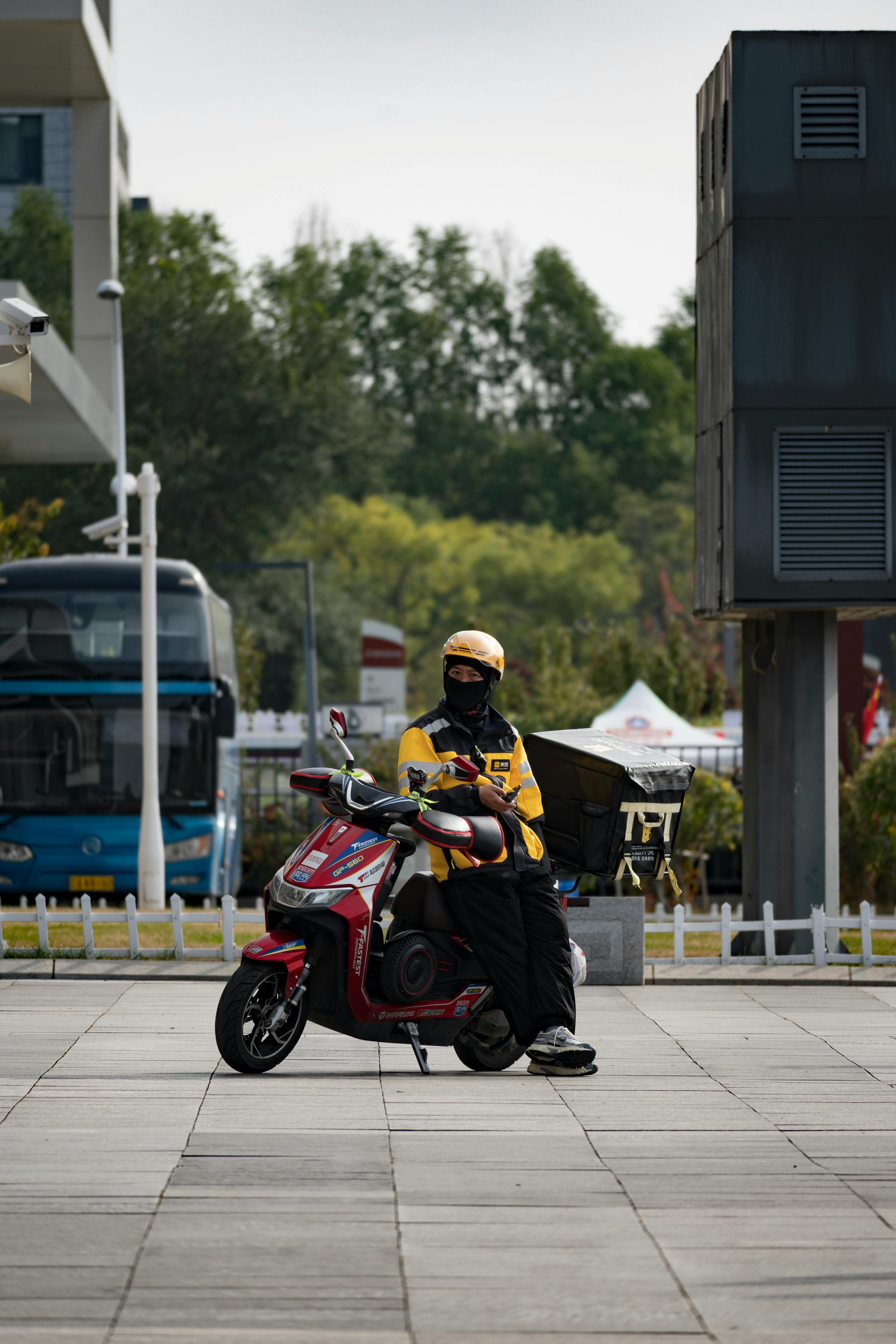Delivery Rider Resting on Scooter in Urban Setting · Free Stock Photo