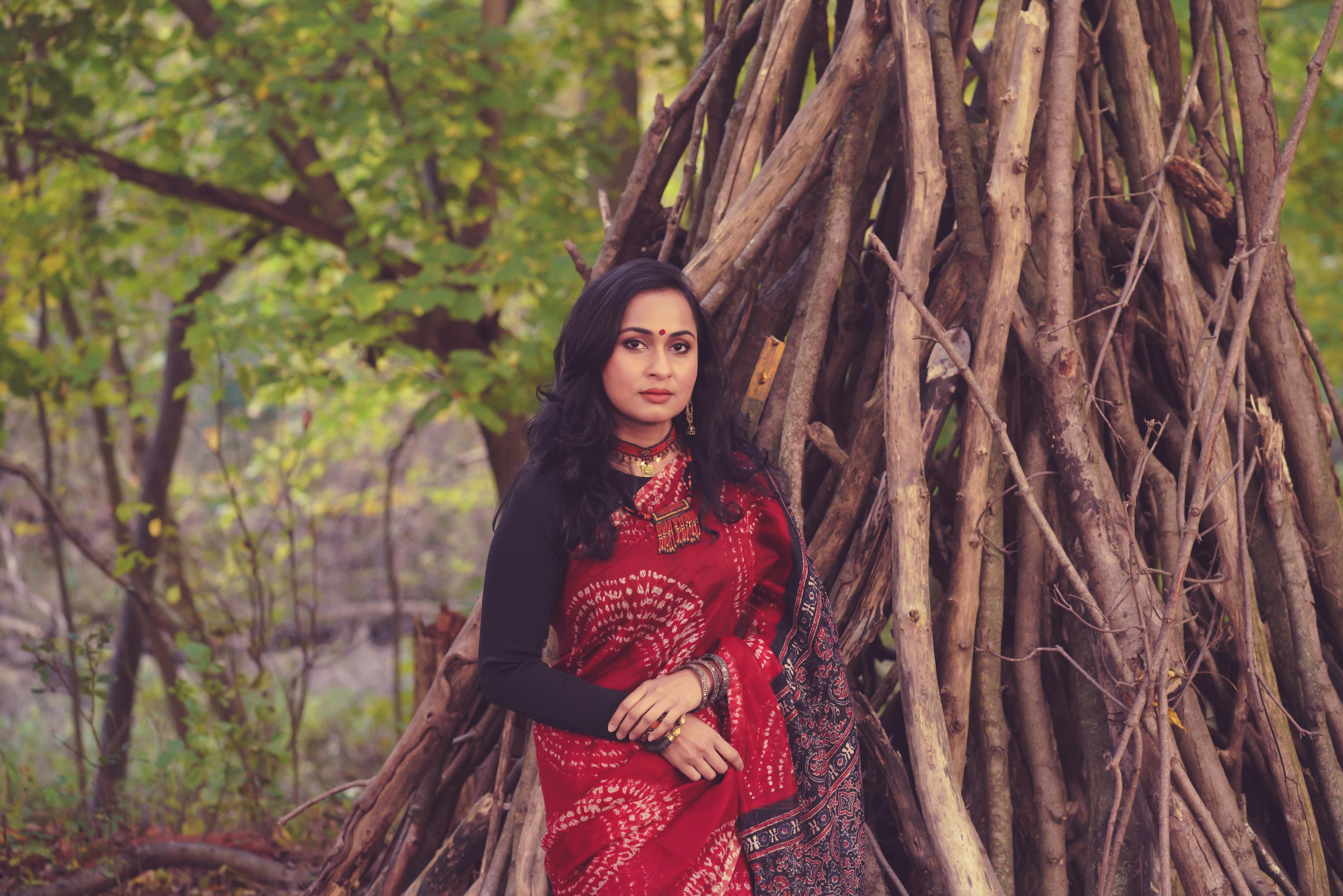 Woman in Traditional Red Attire by Rustic Teepee · Free Stock Photo